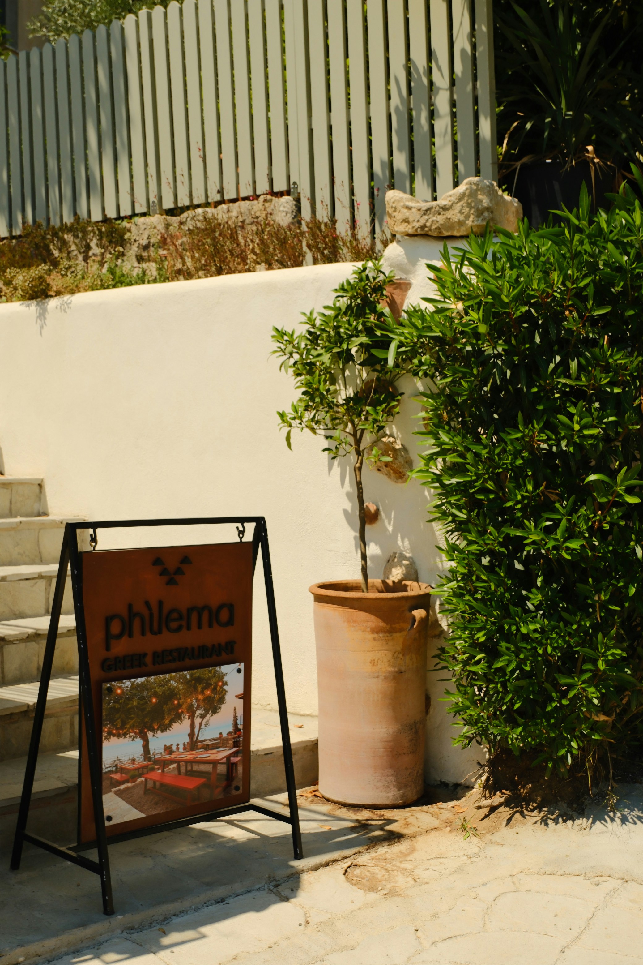 Terracotta Pot and Signboard by a Sunlit Stairway