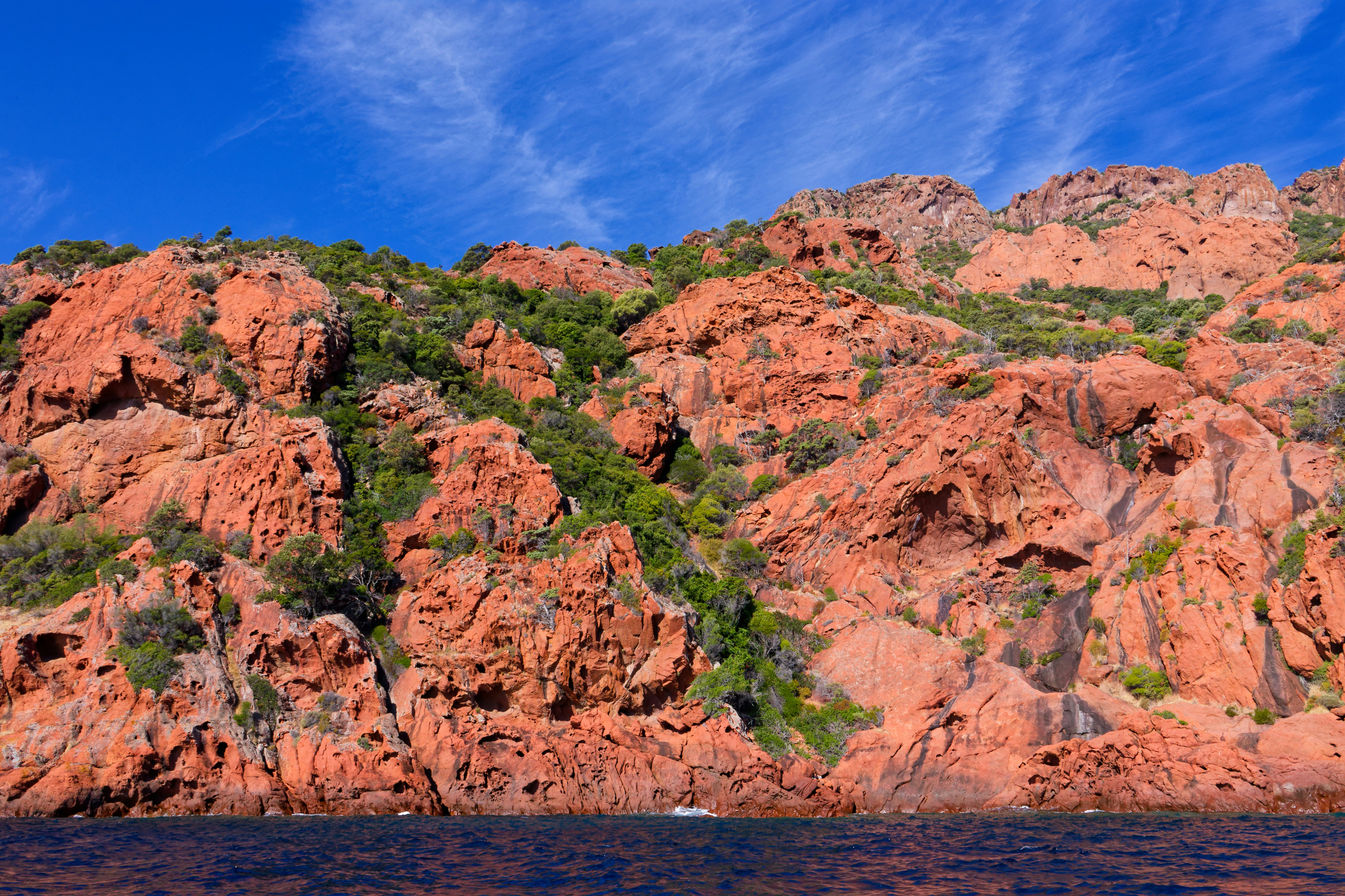 Crimson Cliffs Meeting the Sea Under a Clear Sky