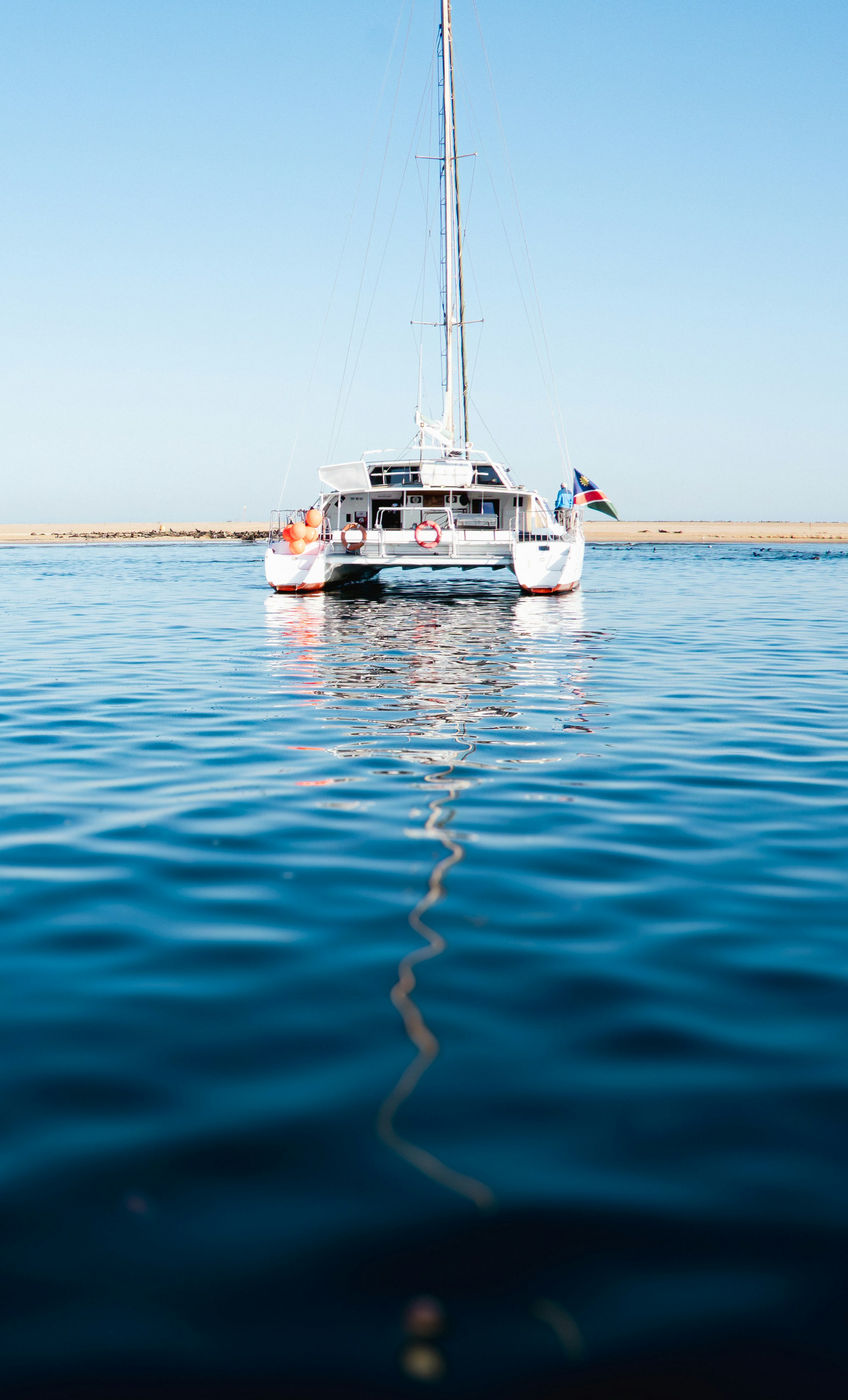Sailing into stillness: a catamaran on calm blue