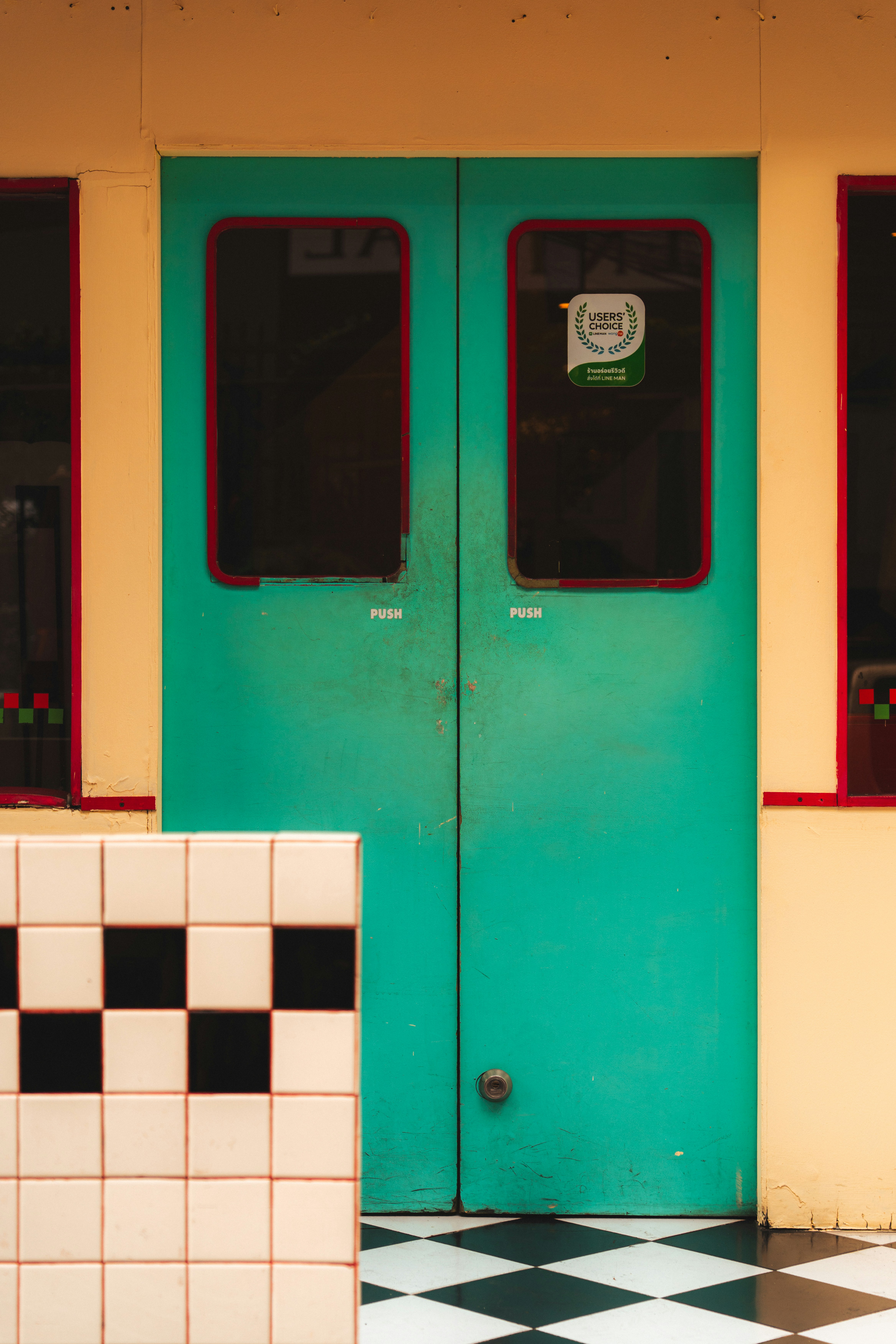 Teal double doors at a retro diner with checkered floor
