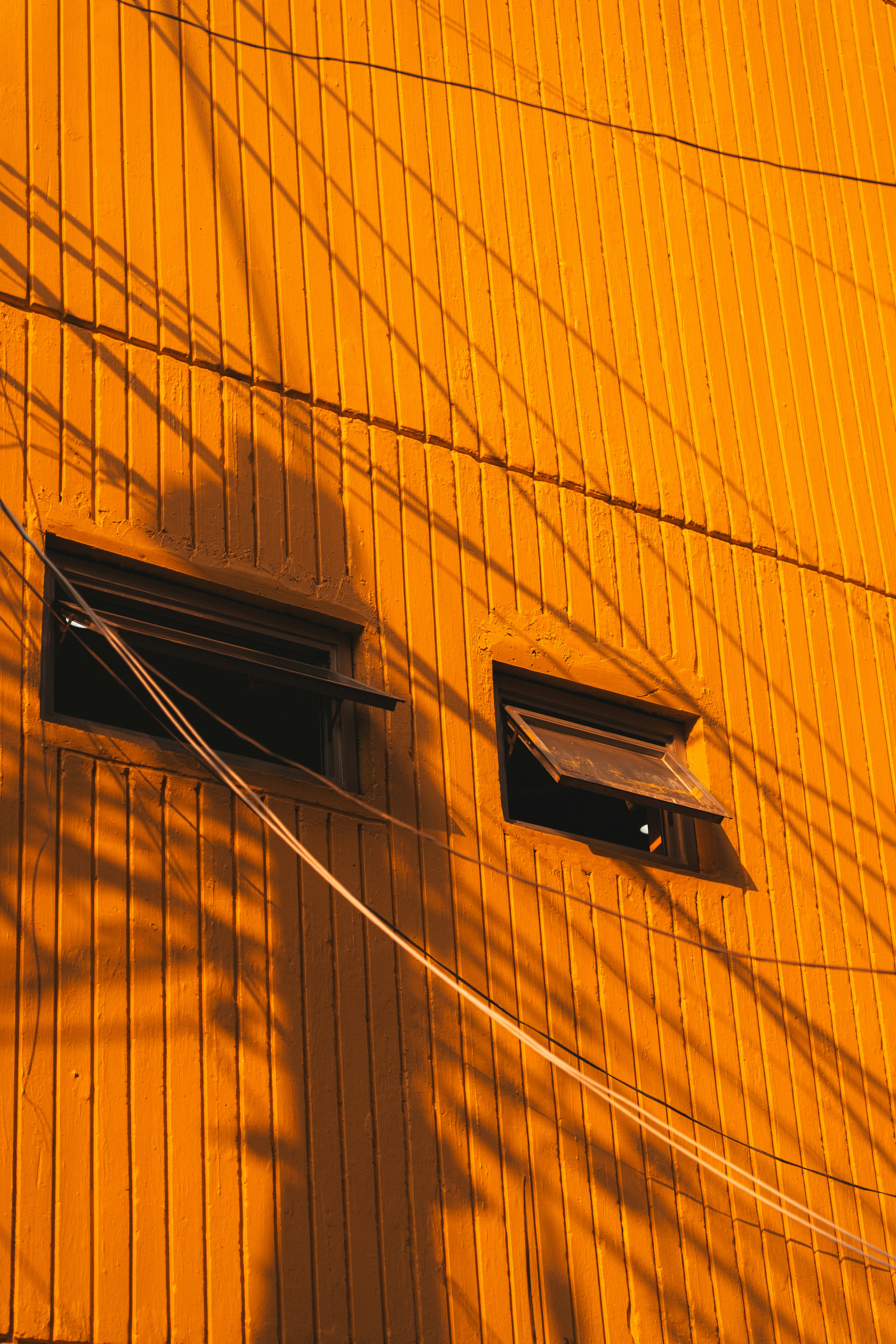 Shadowed Lines on a Sunlit Orange Façade