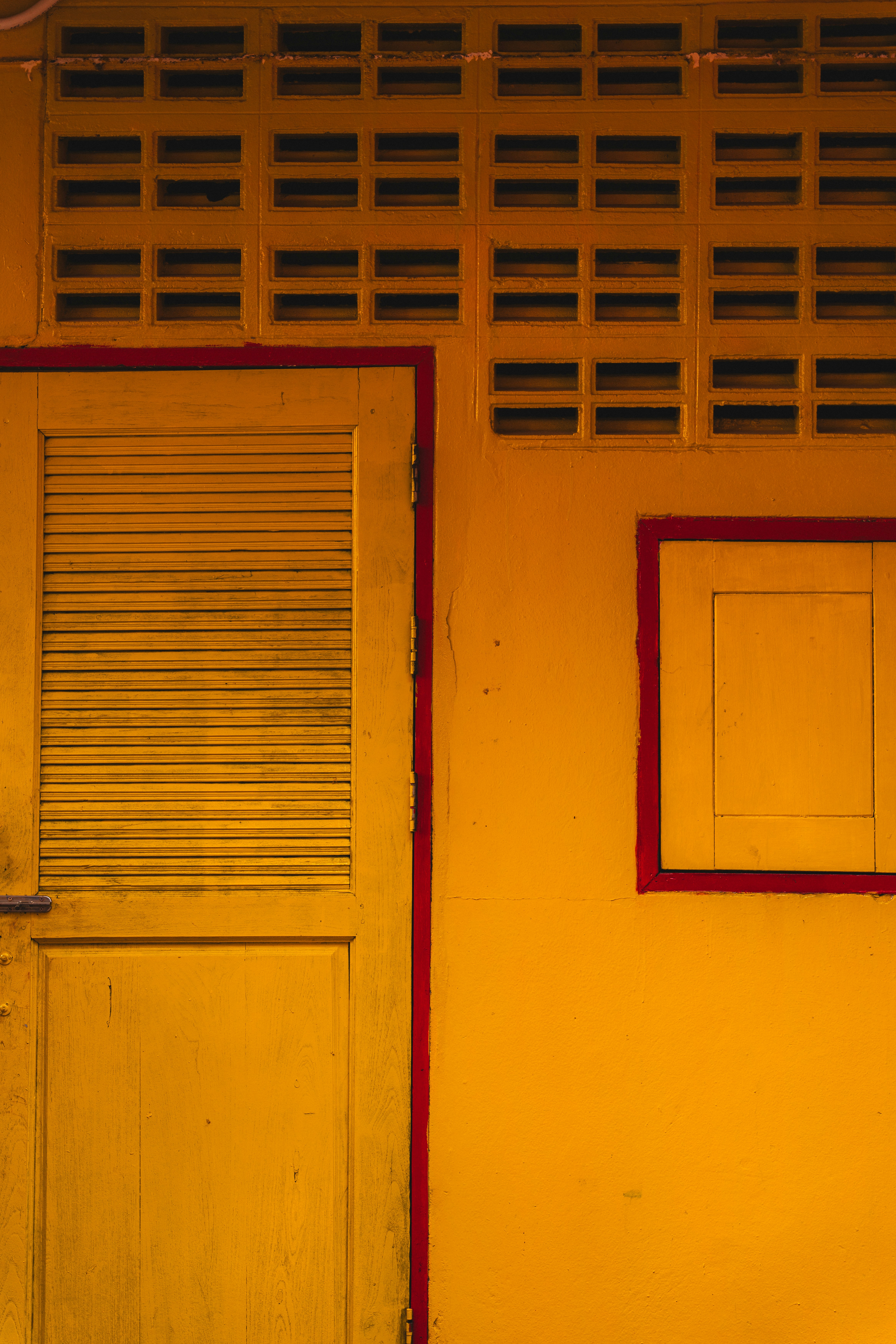 Yellow Facade Geometry: Doors, Grille, and Red Frames