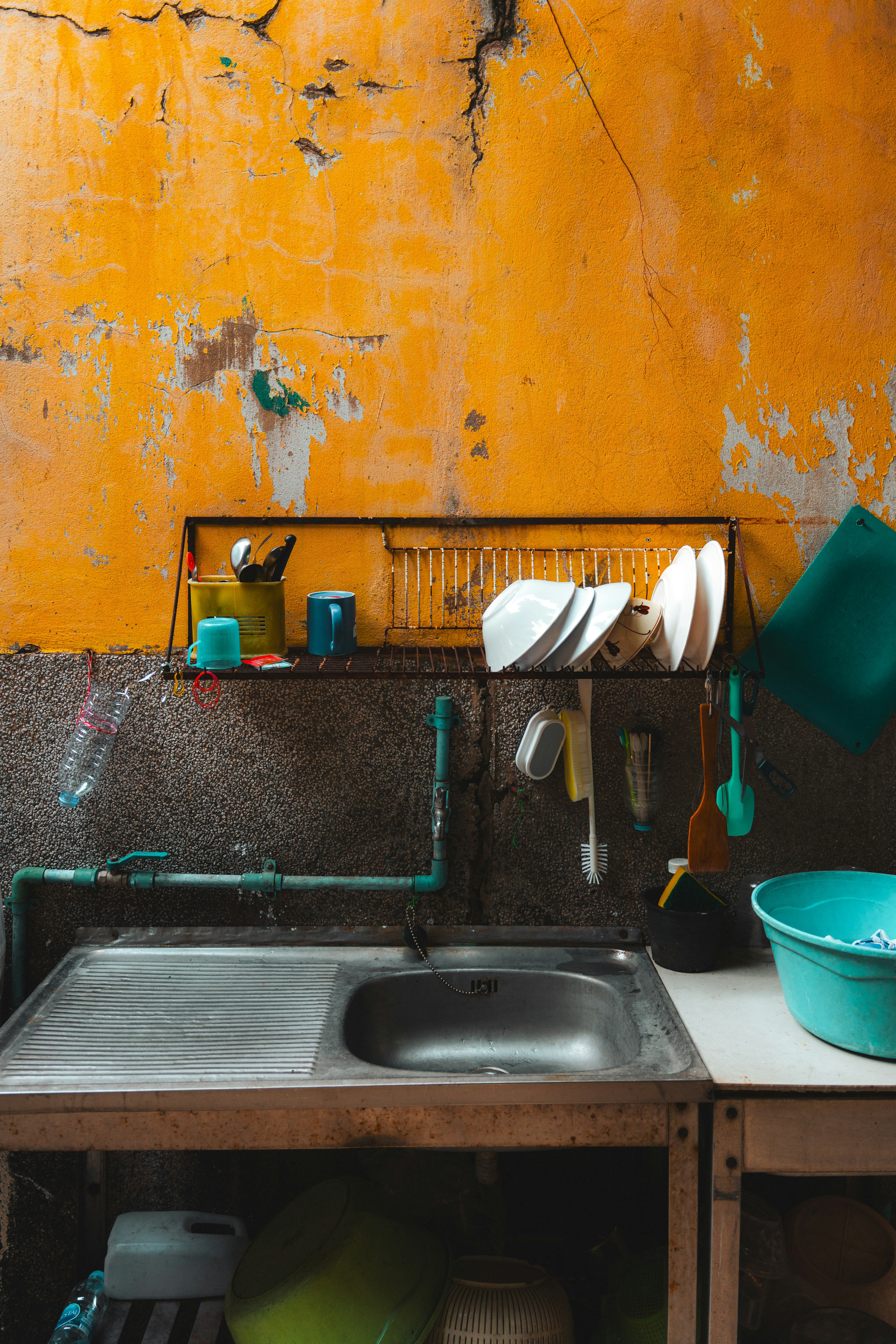 Sunny kumquat: a weathered orange sinkscape with dish rack and tools