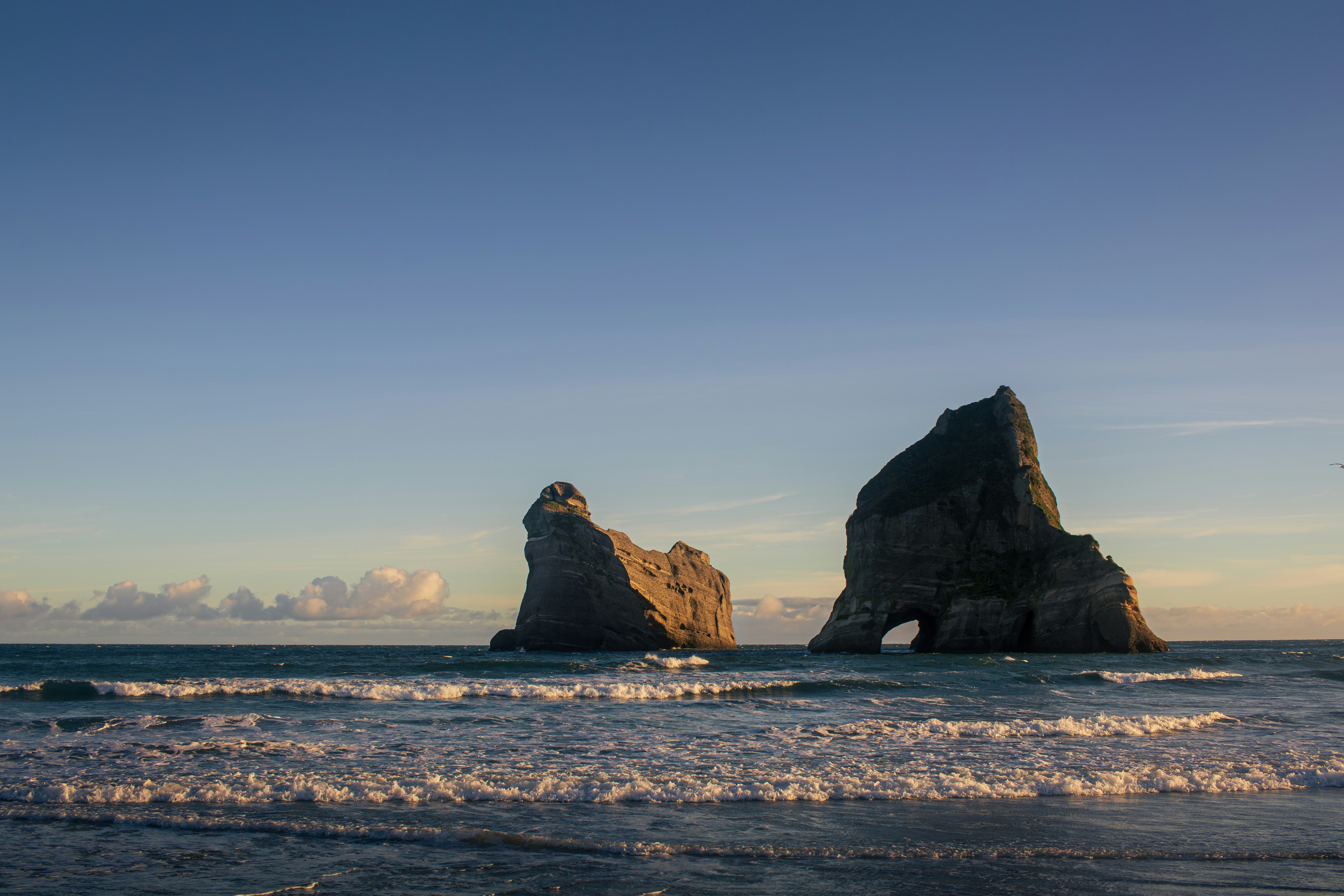 Sea Stacks at Dusk: Two Rock Formations Rising from Gentle Waves