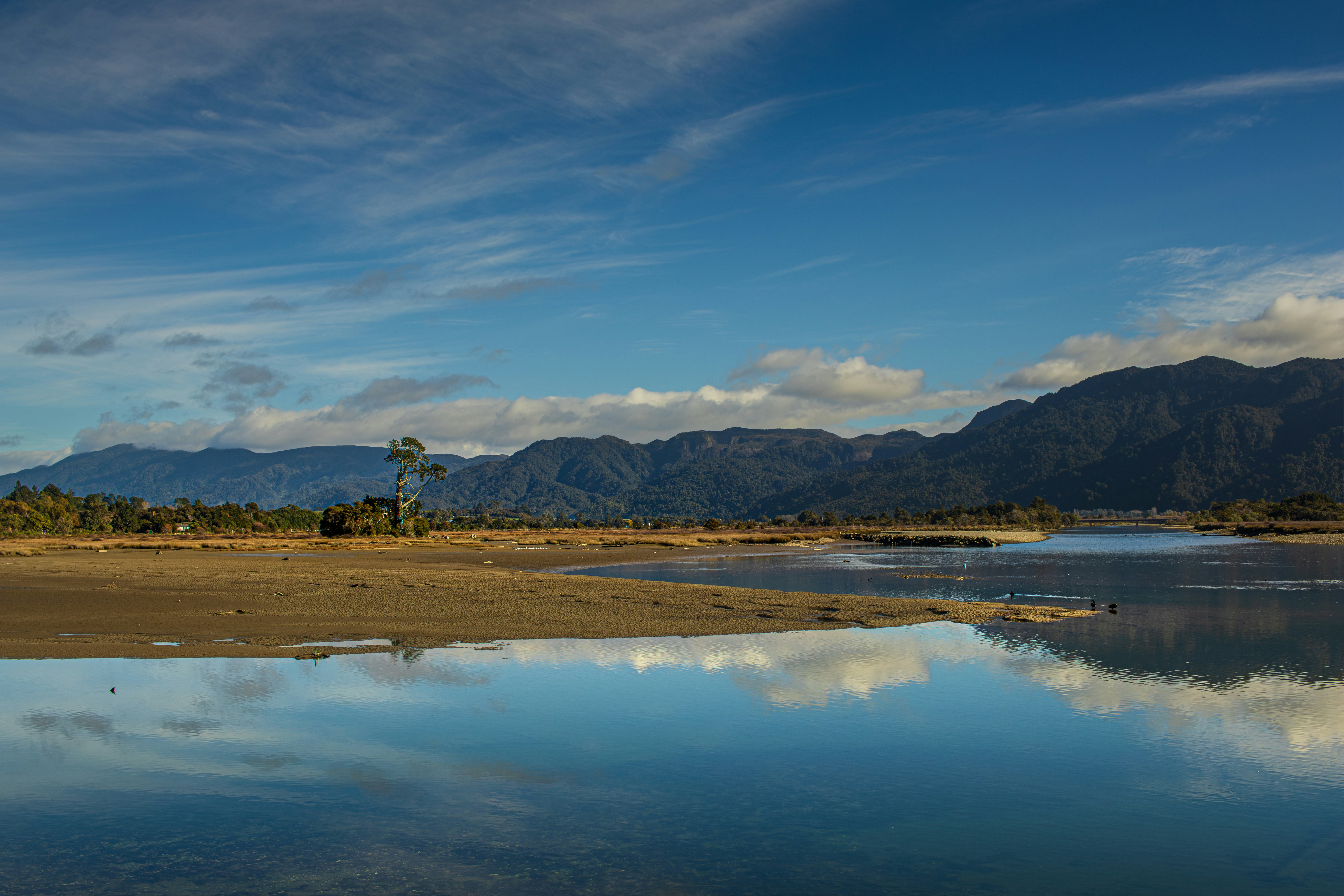 Mirror of Peaks: A Tranquil River Reflects a Mountain Range