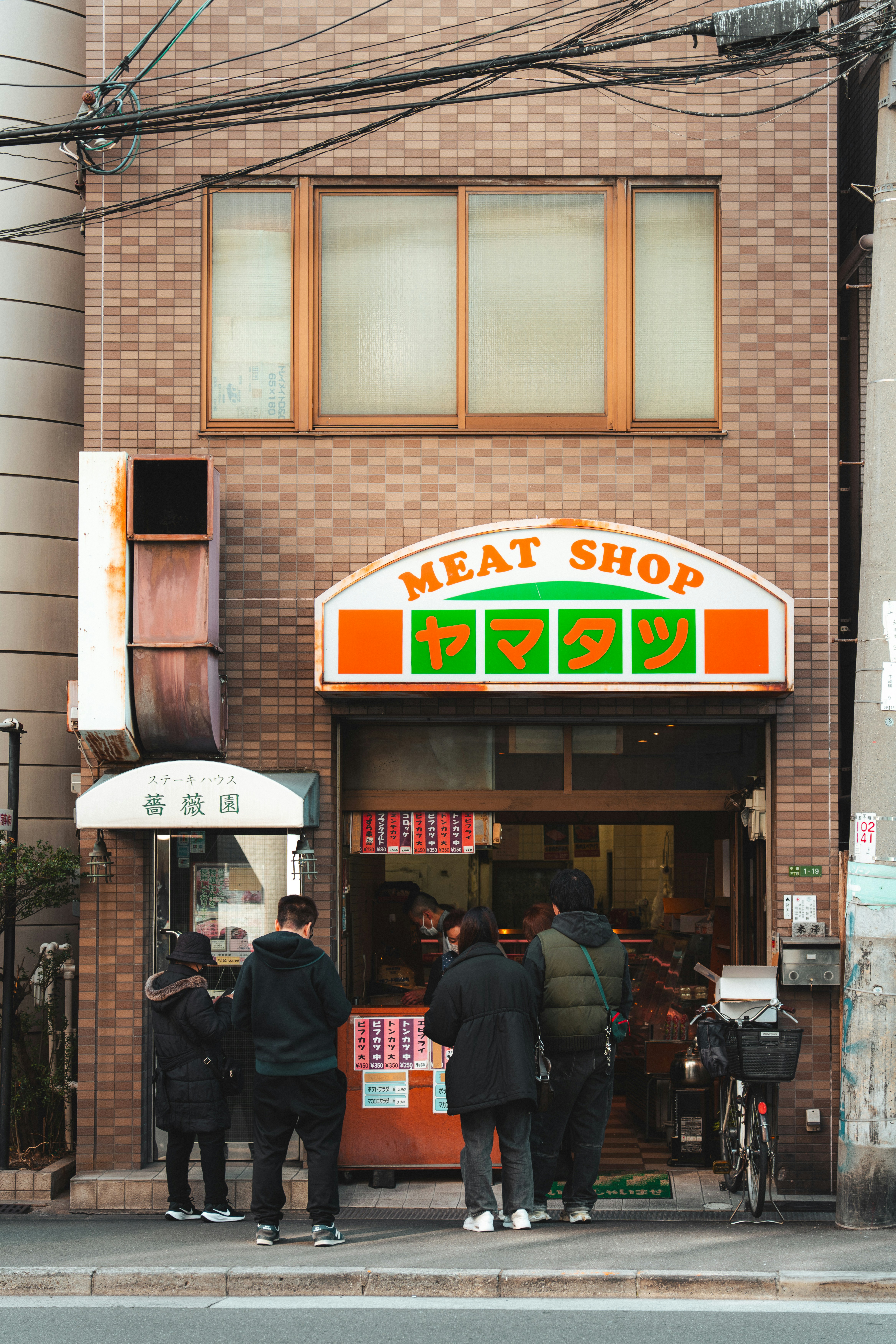 Yamatsushi Meat Shop: Neon Signage Framing a Quiet Queue