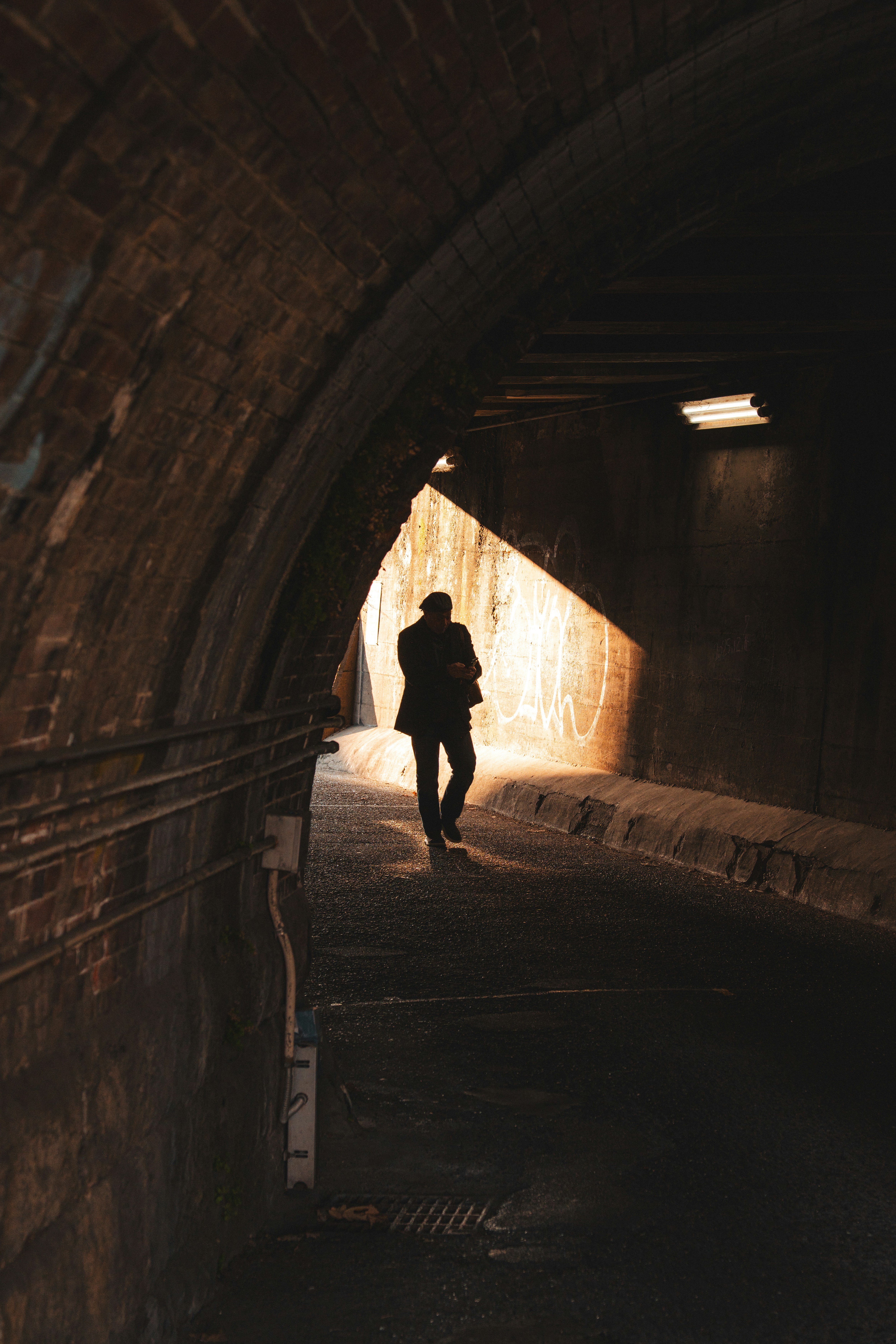 Footsteps in the Dim Arc: A Stranger Emerges from the Tunnel Light