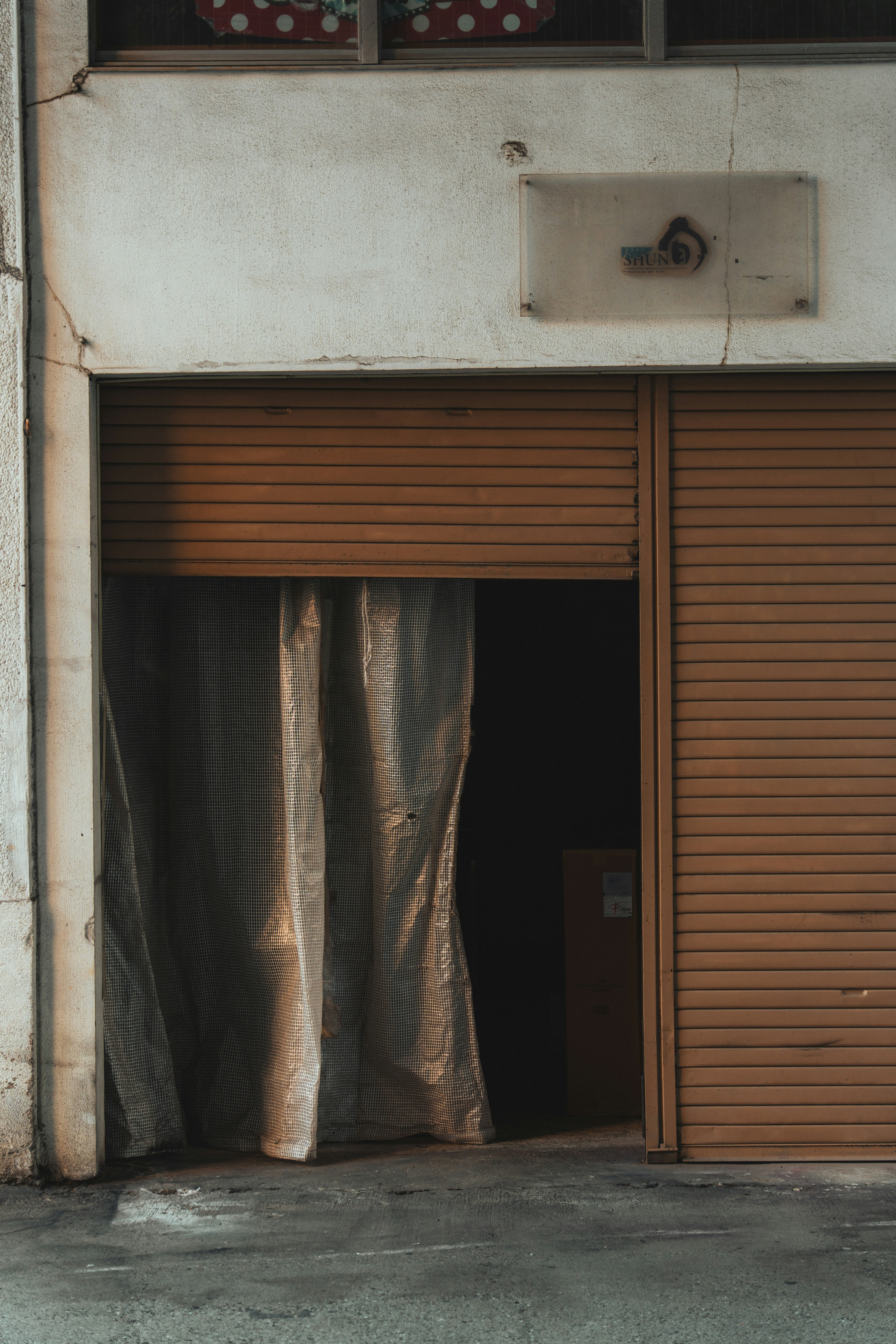 Abandoned storefront with tattered curtain doorway