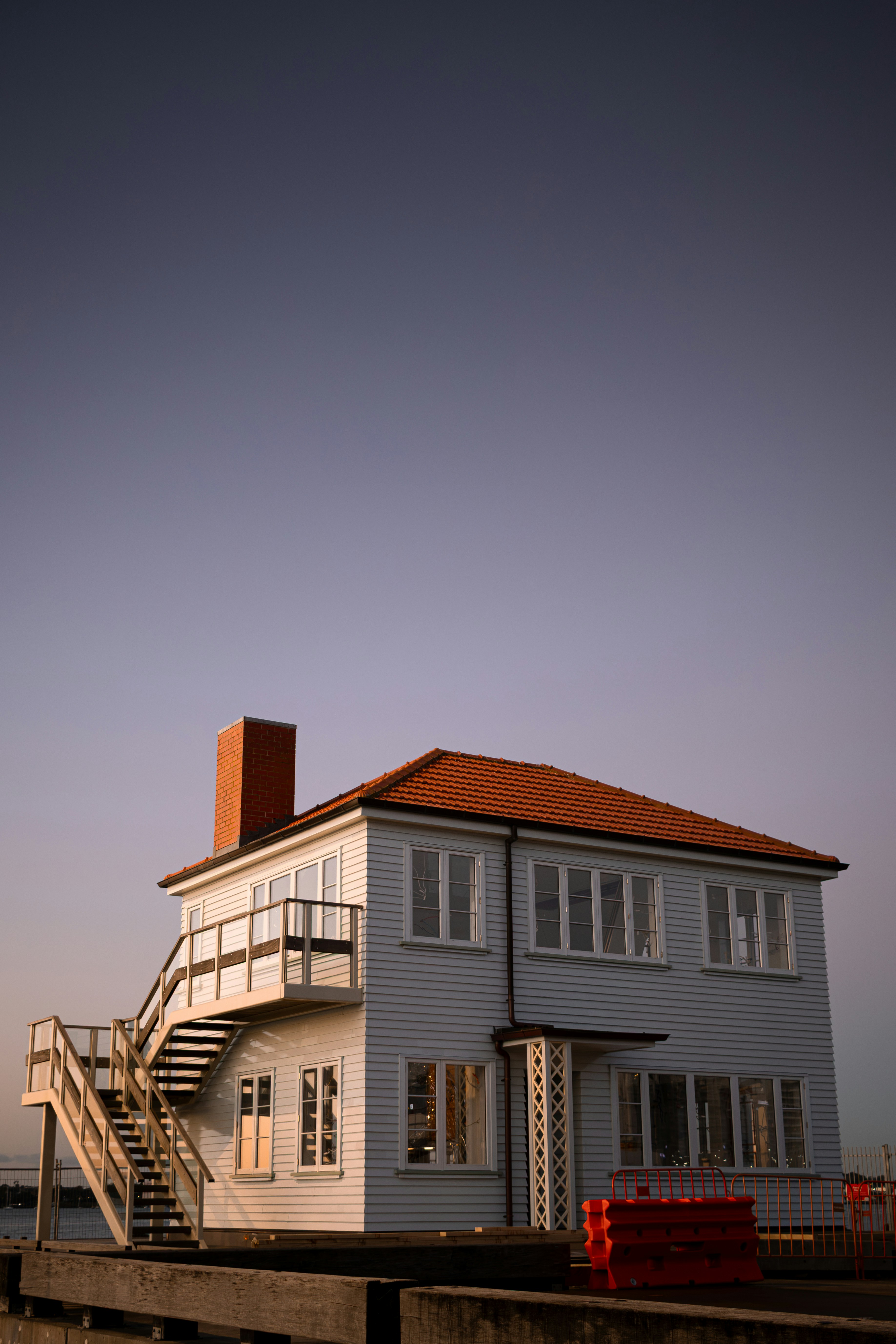 White Coastal House at Dusk with Red Roof Persuasive Calm