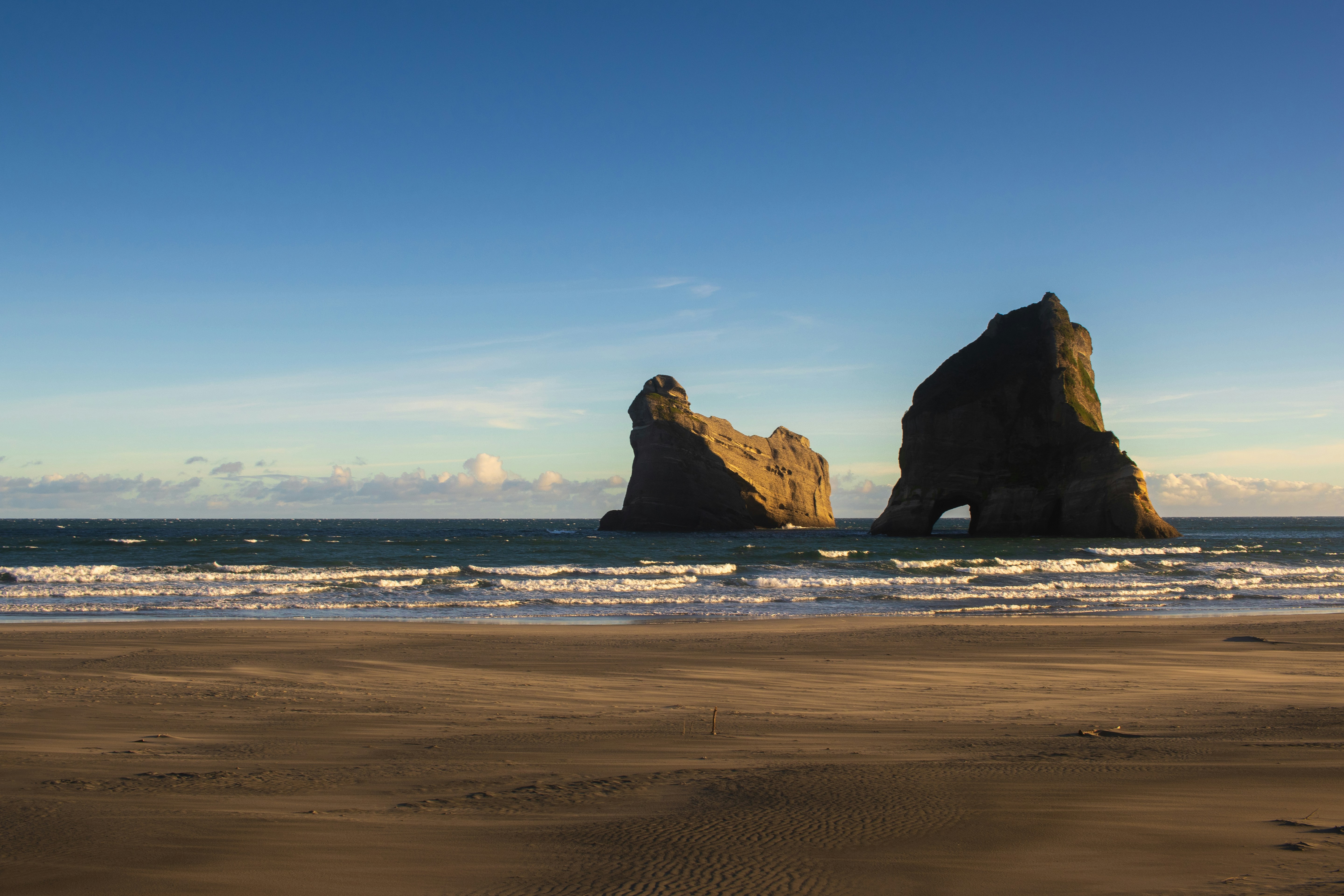 Sea Stacks at Dusk: Two Rock sentinels rising from a quiet shore