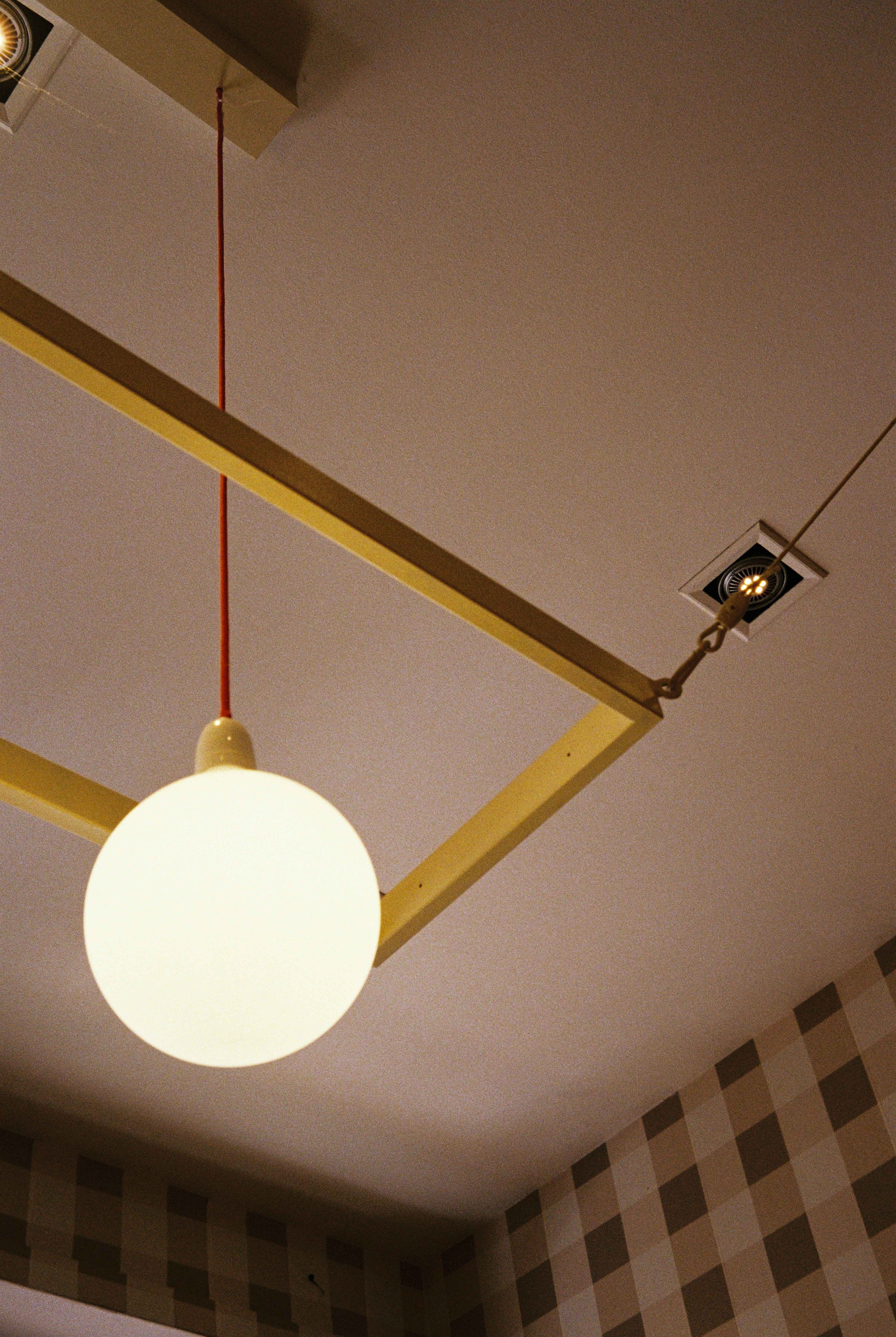 Overhead Glow: A Modern Ceiling Scene with Geometric Beams and a Round Luminary