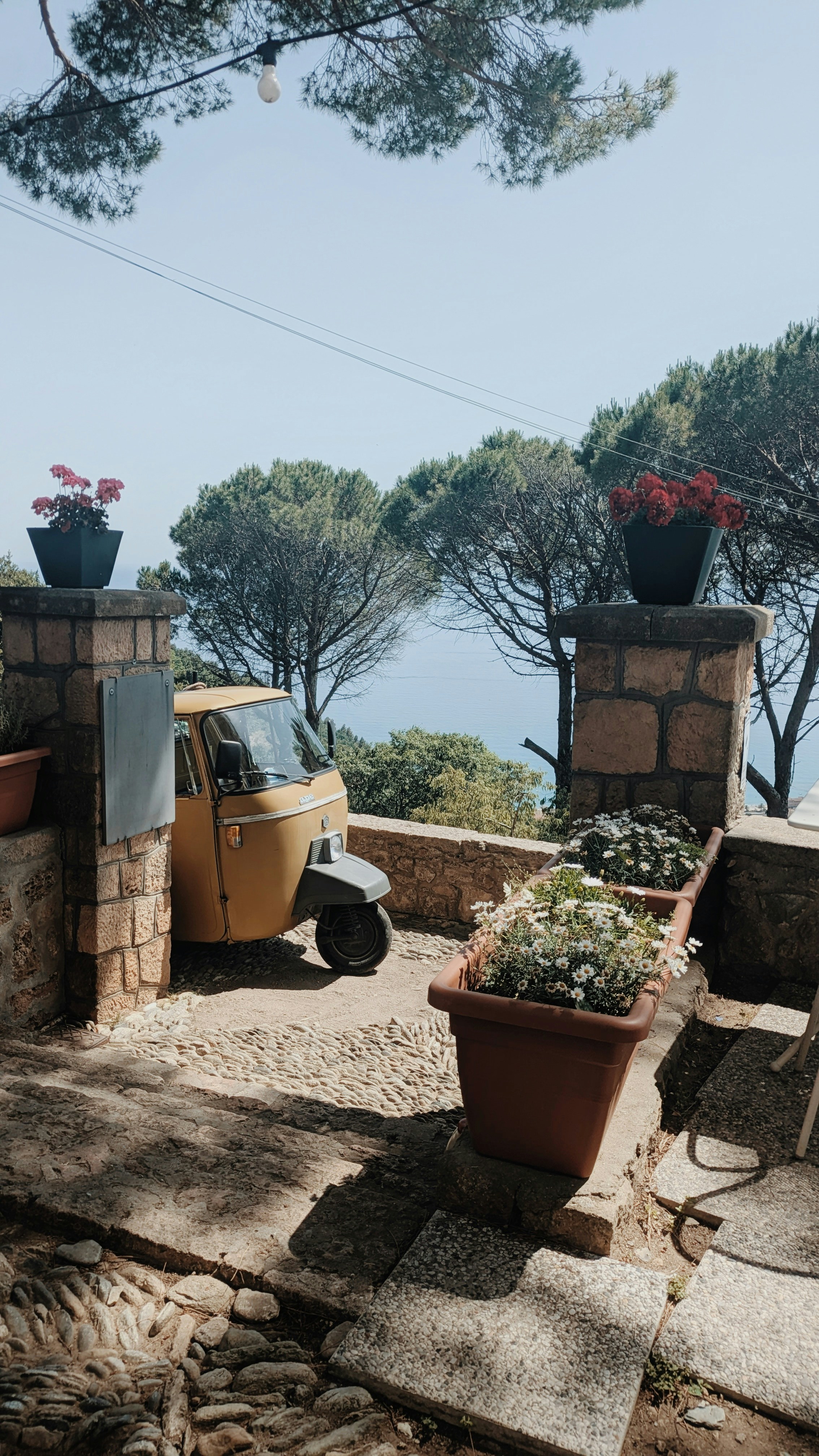Yellow Vespa by the Terrace: A Sunlit Pause Above the Sea