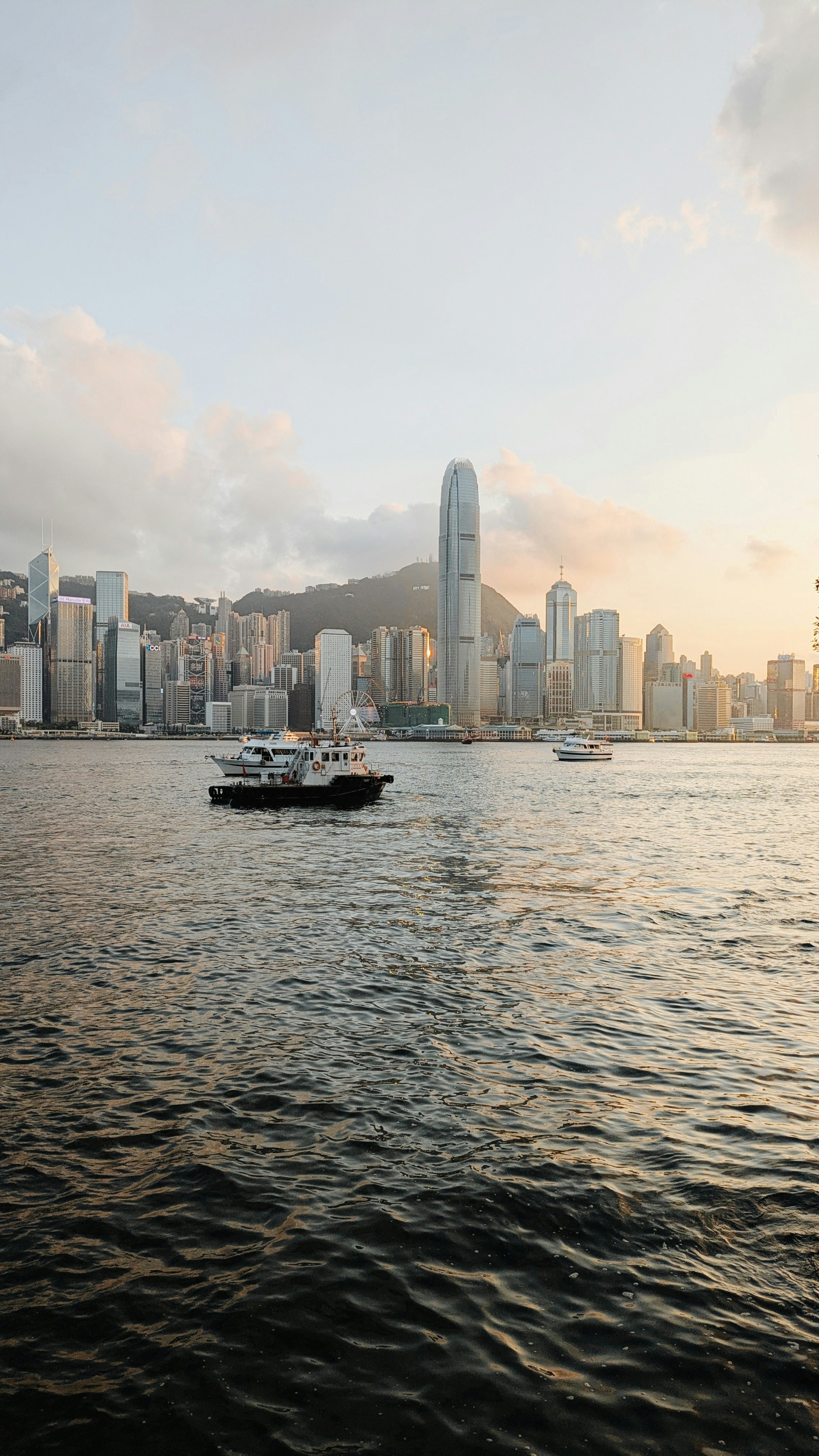 Hong Kong Skyline at Dusk: Boats Glide Across the Harbor