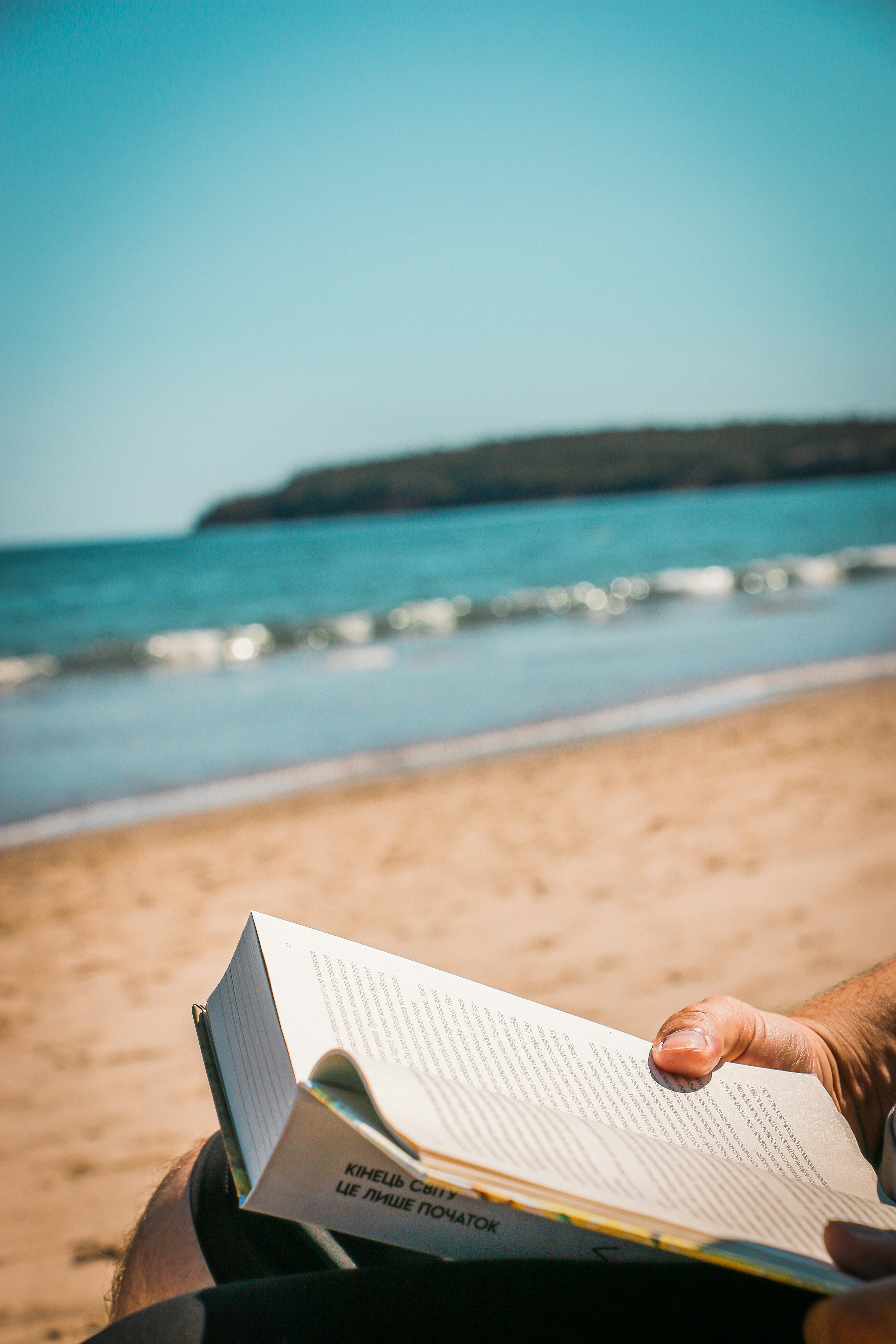 Reading on the Beach: A Quiet Moment with a Paperback by the Shore