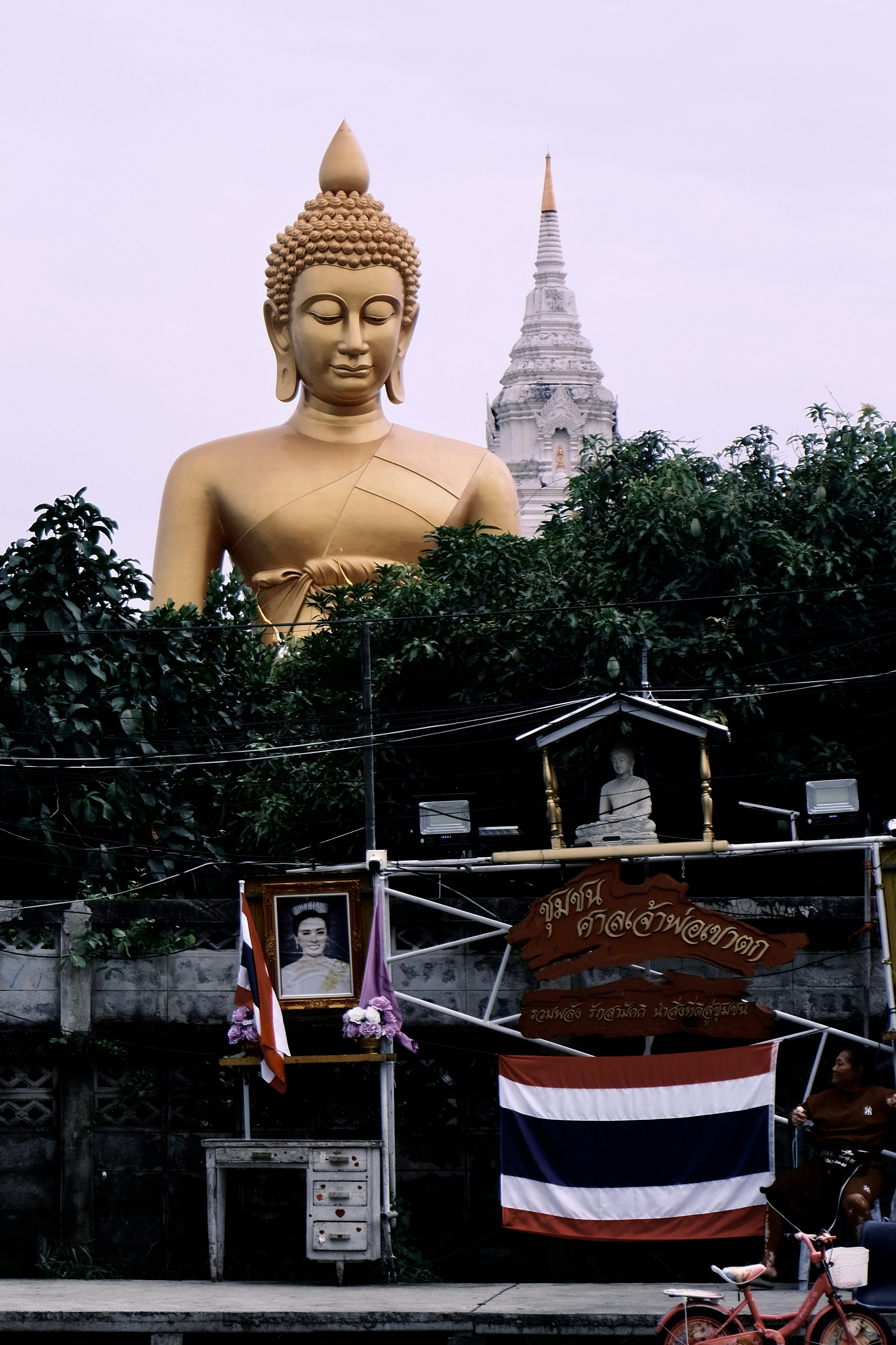 Golden Buddha Overlooked by Shrine and Thai Flag