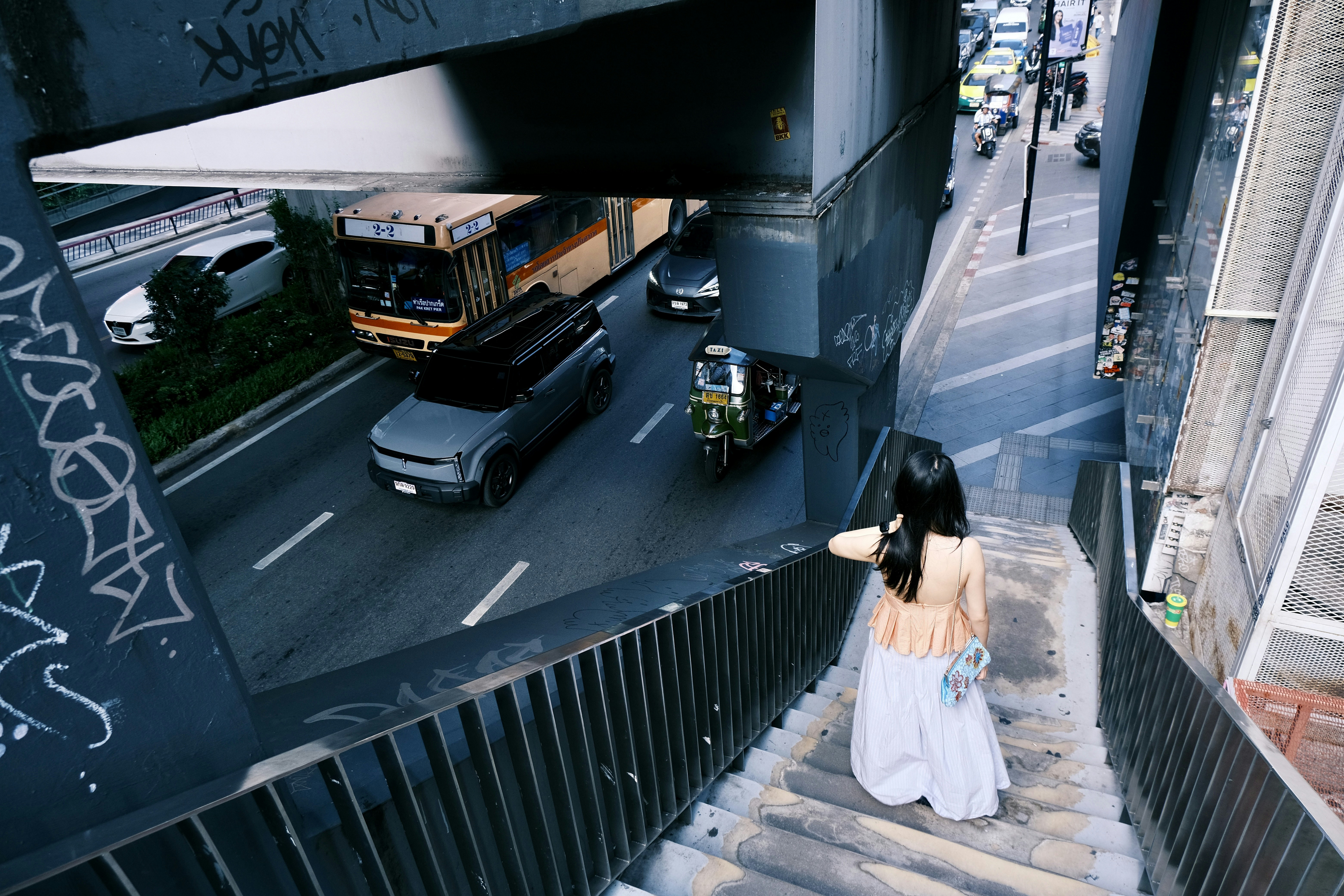 A Quiet Staircase to the Street: A Woman Descends in Soft Light