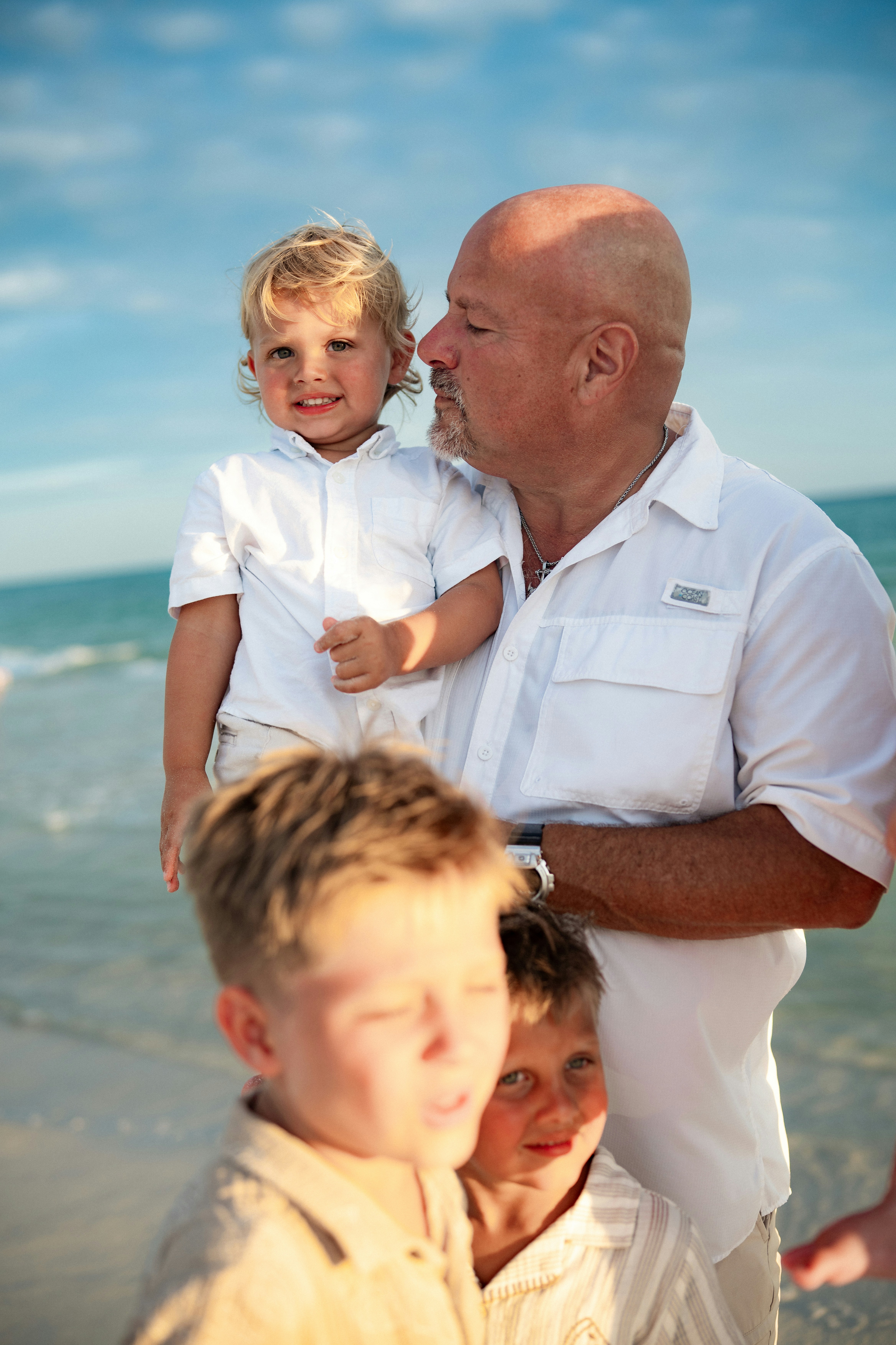 Sunlit Beach Portrait: A Father and Sons Moment