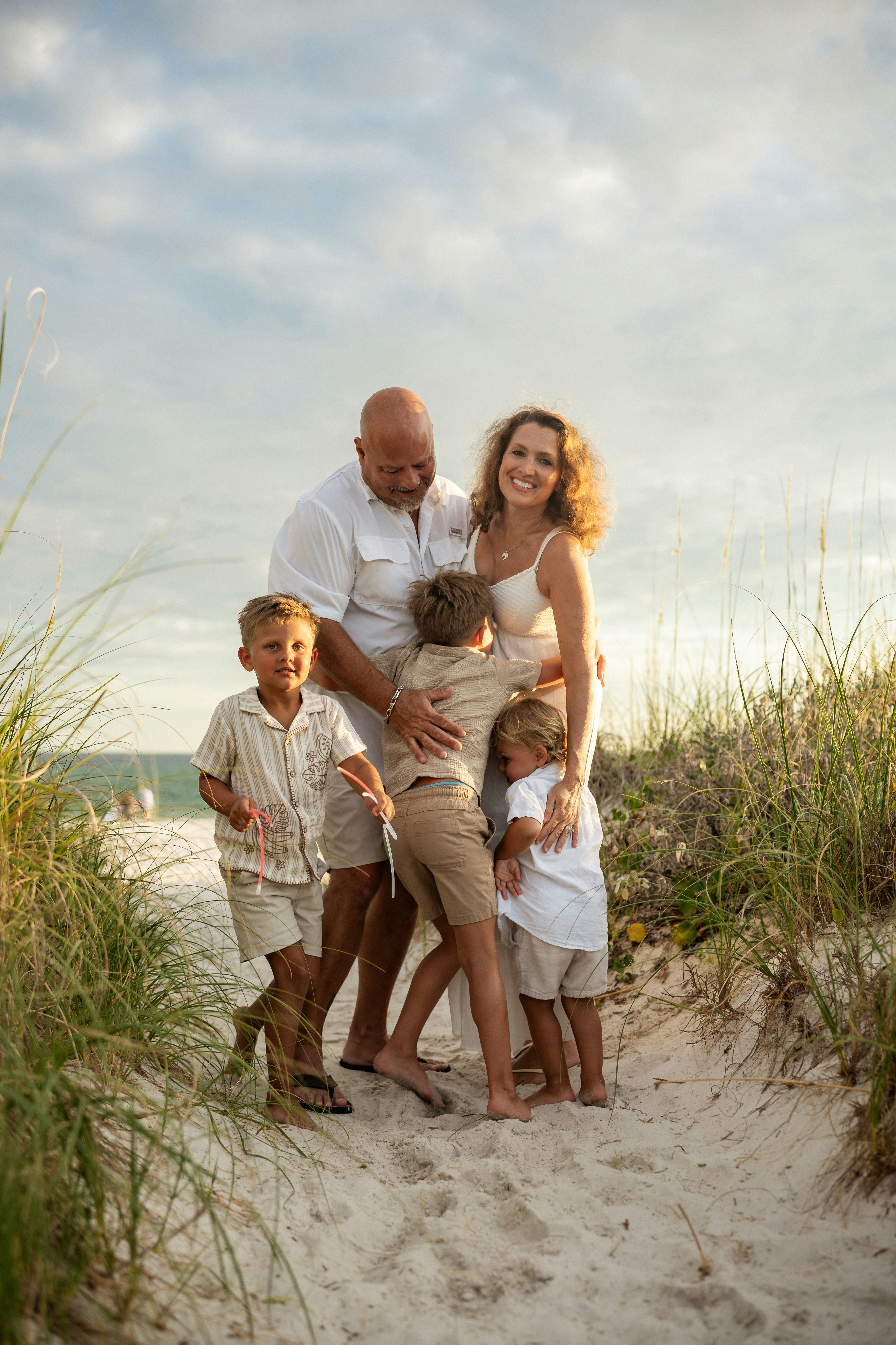 Family on a sunlit dune: laughter and warmth by the sea