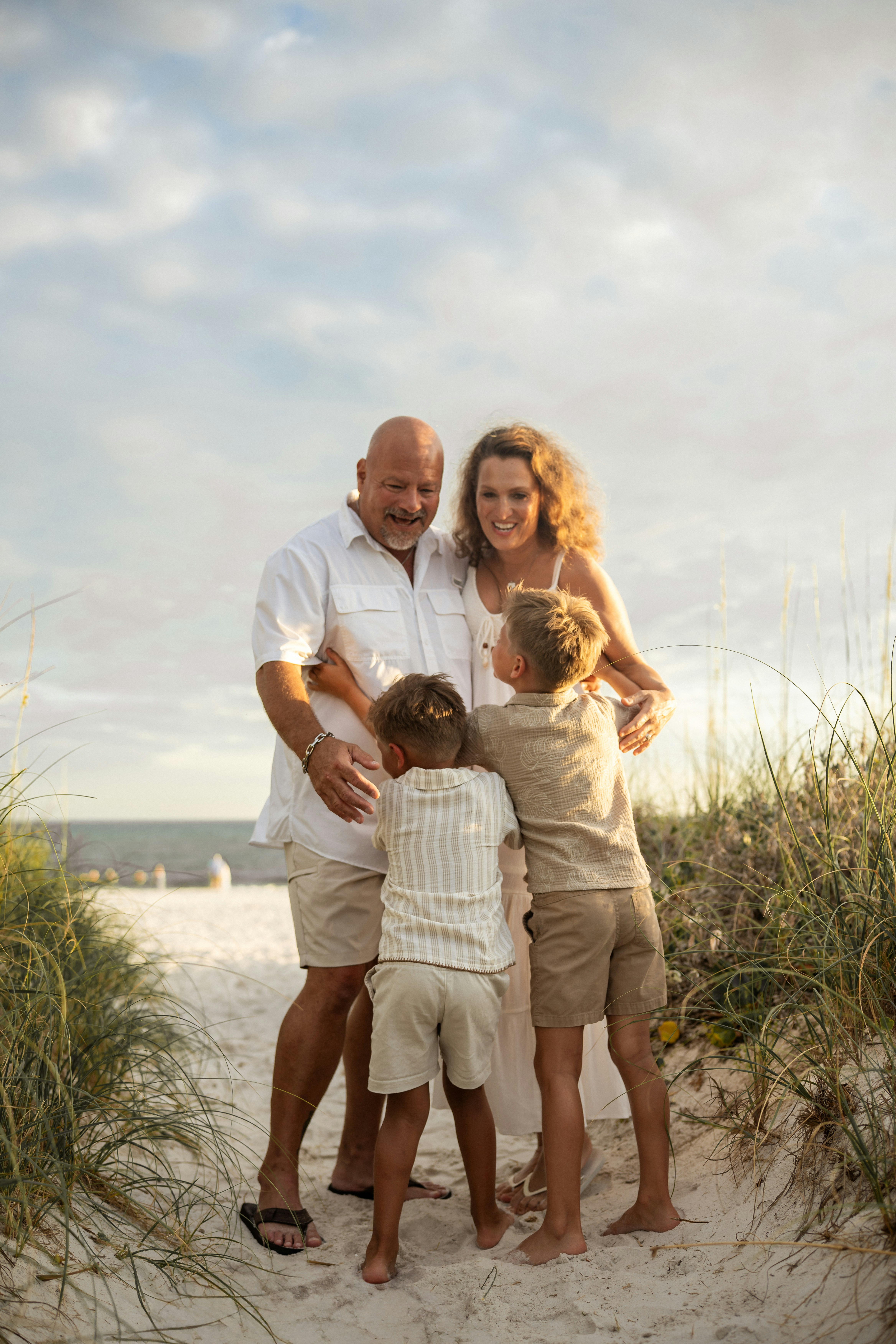 Family Beach Hug: Sunlit Joy on a Sandy Dune