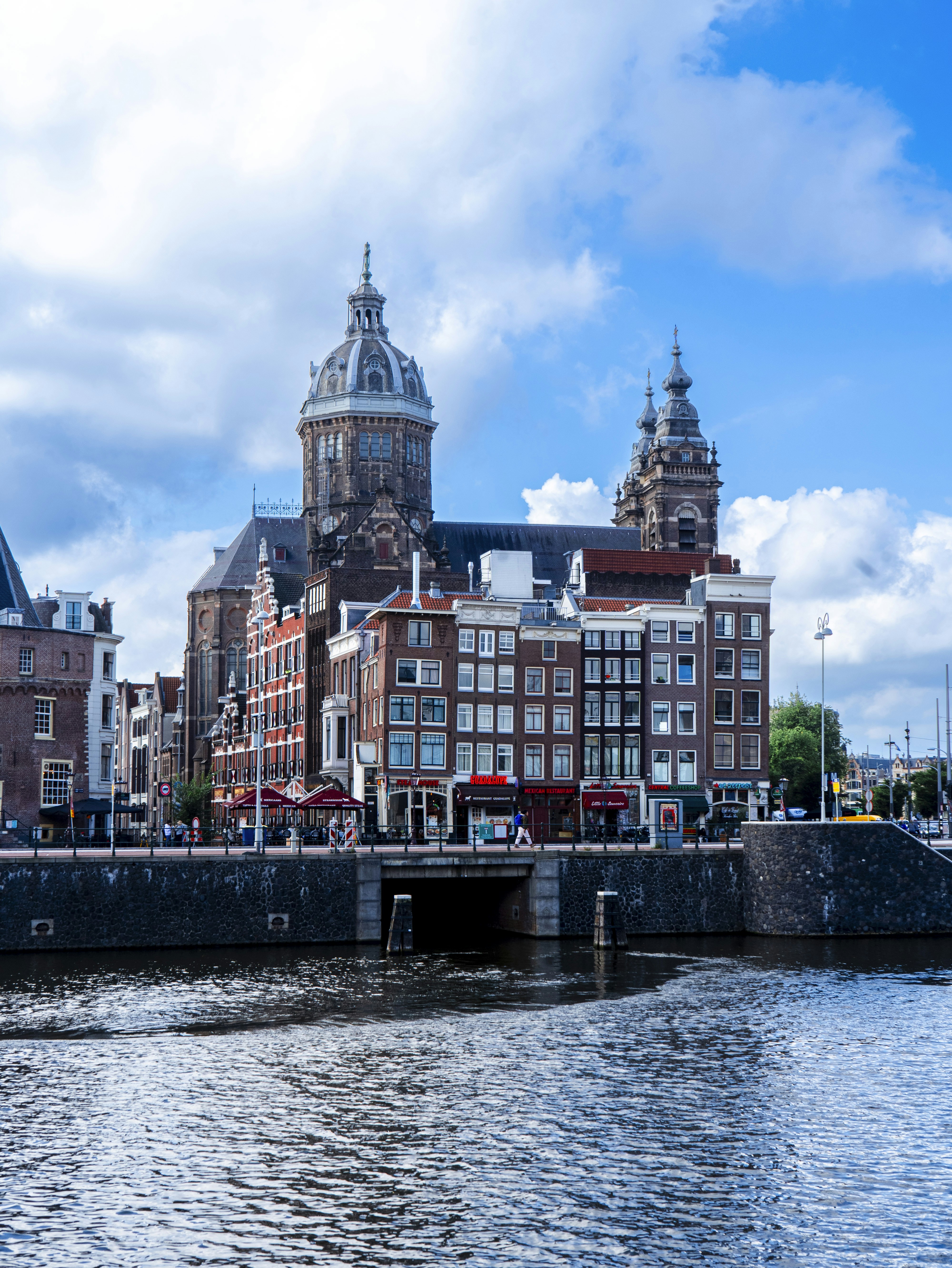 City Facade by the Canal: Towers and Brick Row Along the Water