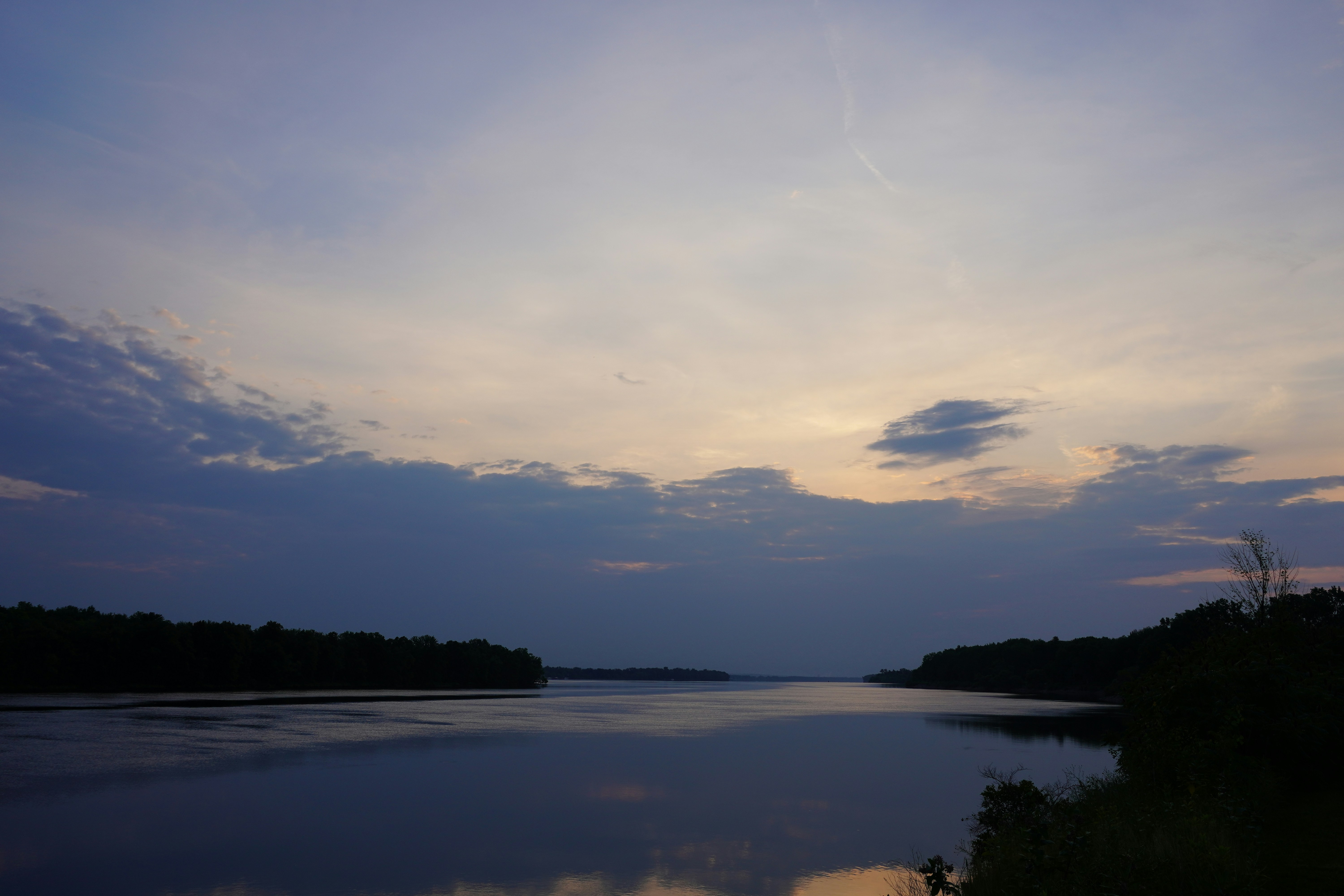Dusk Over a Still River: Silhouetted Banks at Horizon
