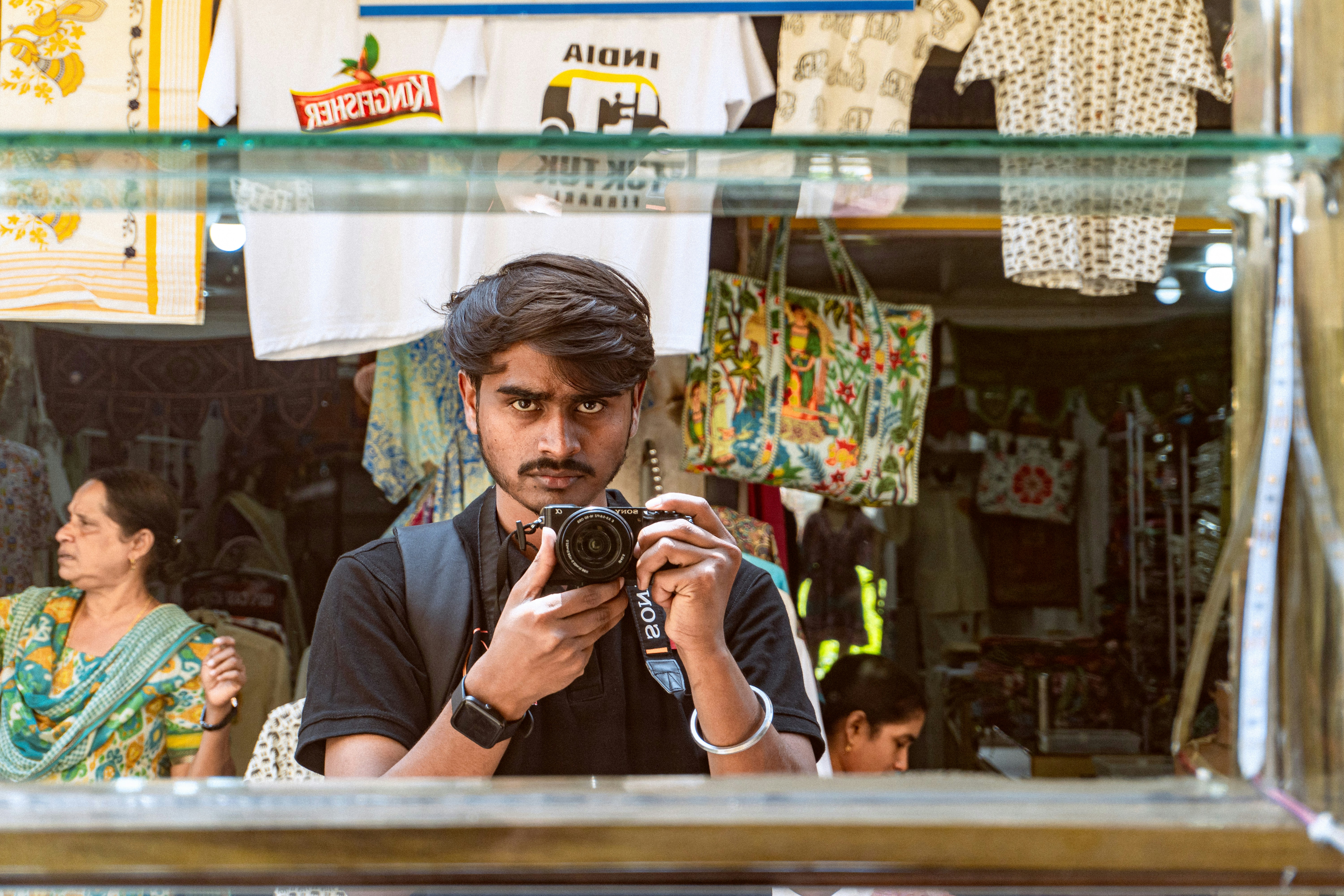 Through the Lens: A Portrait in a Busy Delhi Shop Window