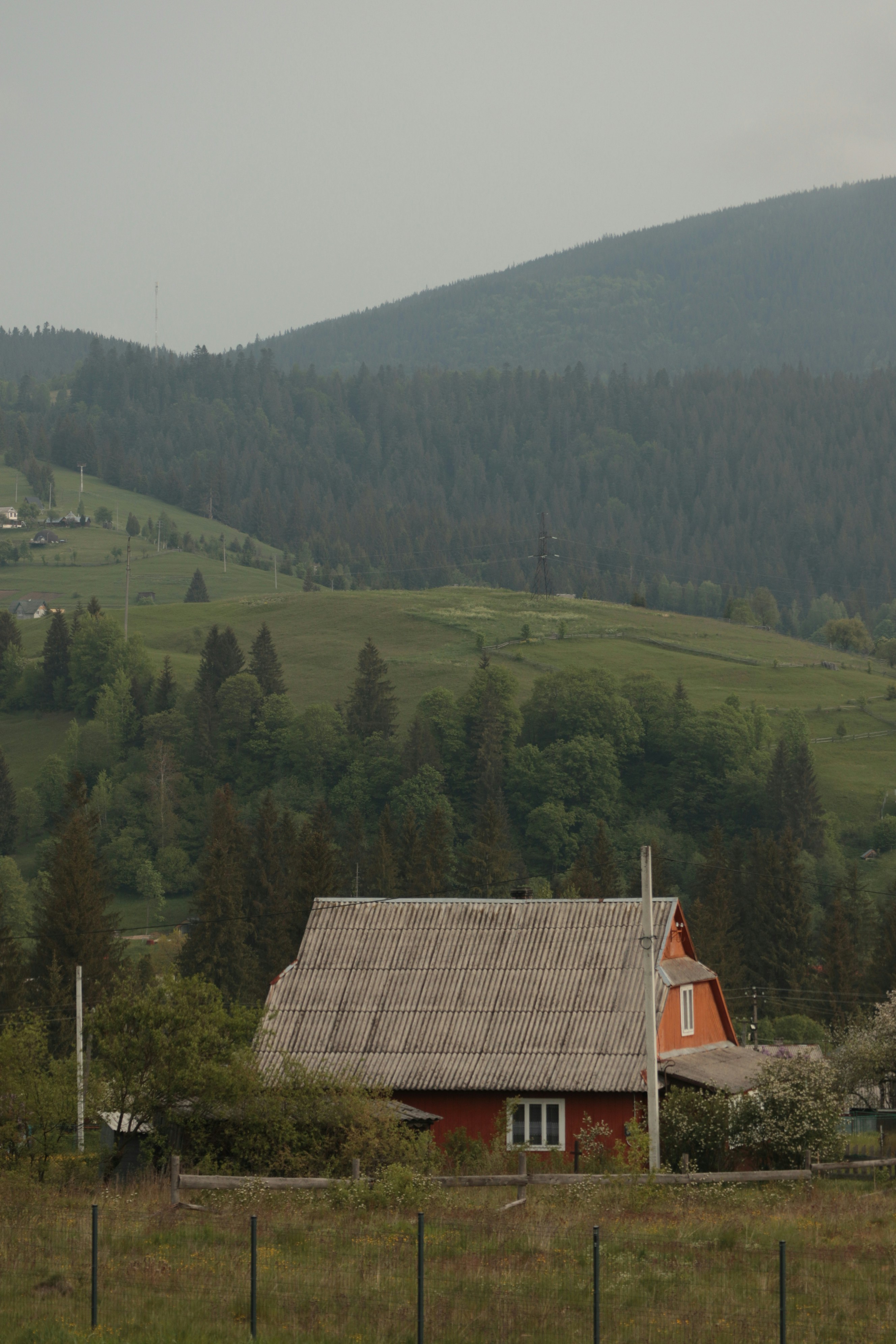 Red-roofed cottage tucked in the hillside at dusk