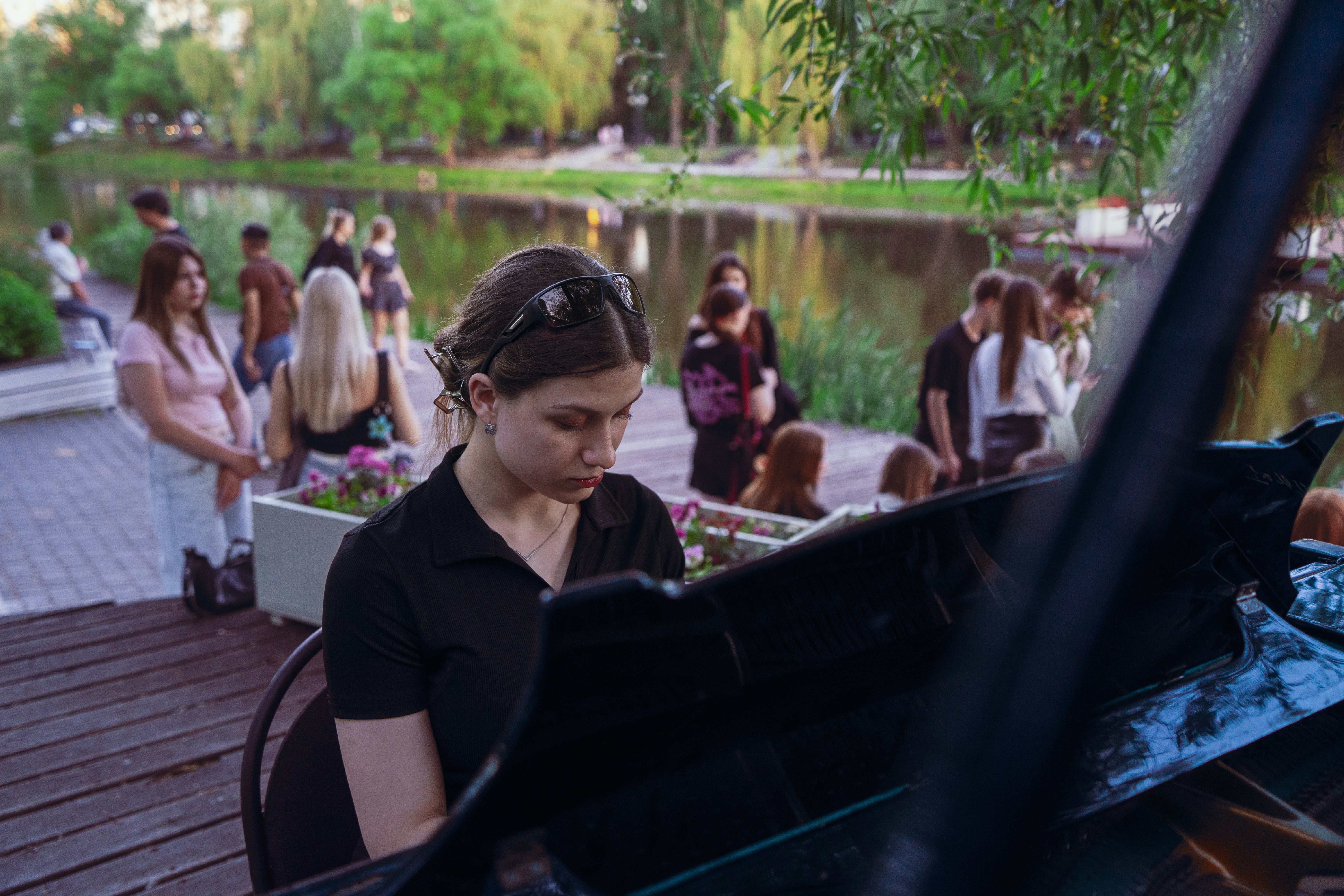 Piano Bar by the Pond: a musician soaking in the moment amid dusk-lit onlookers