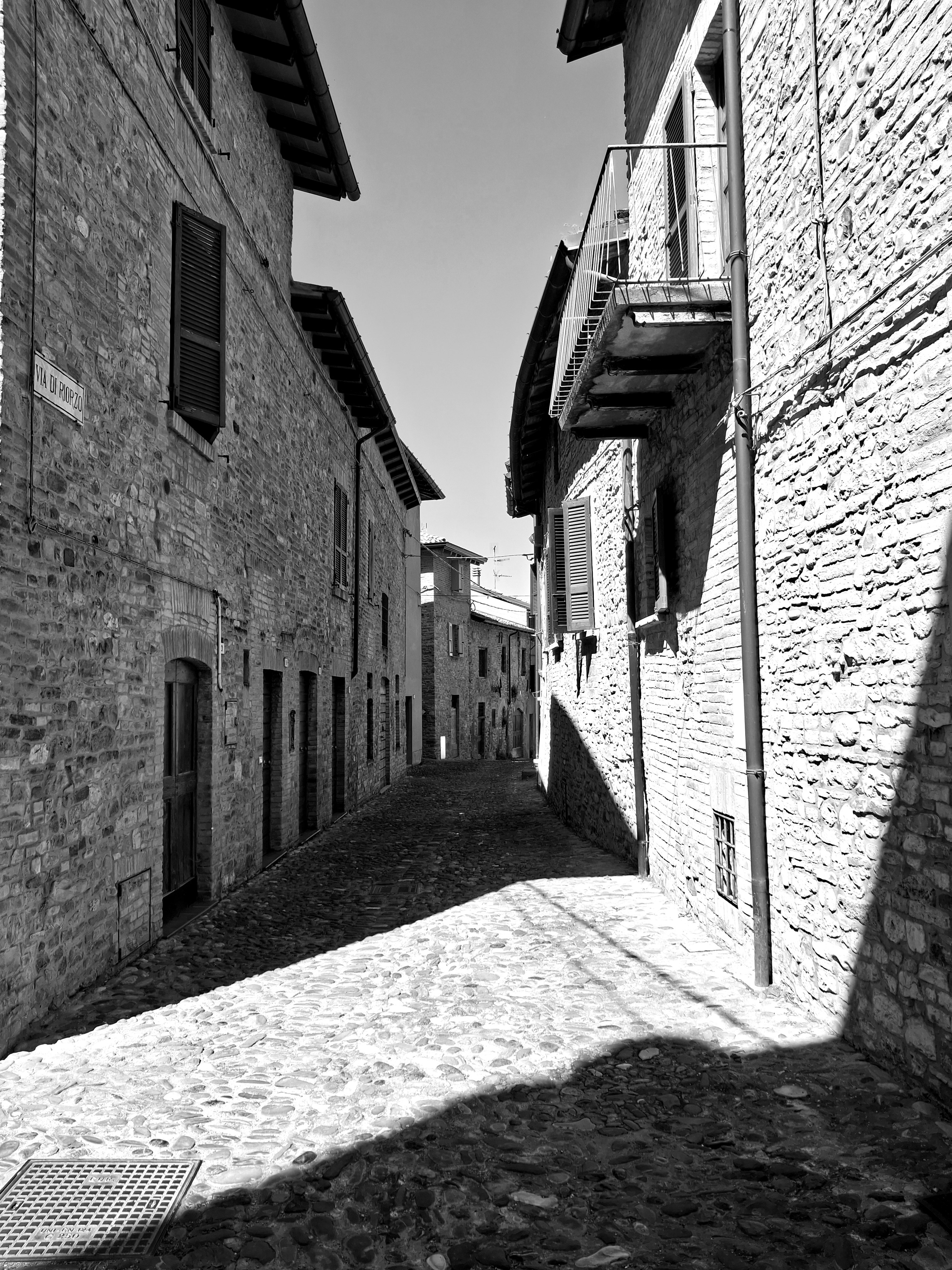 Shadowed Calle at Dusk: A Quiet Stone Corridor