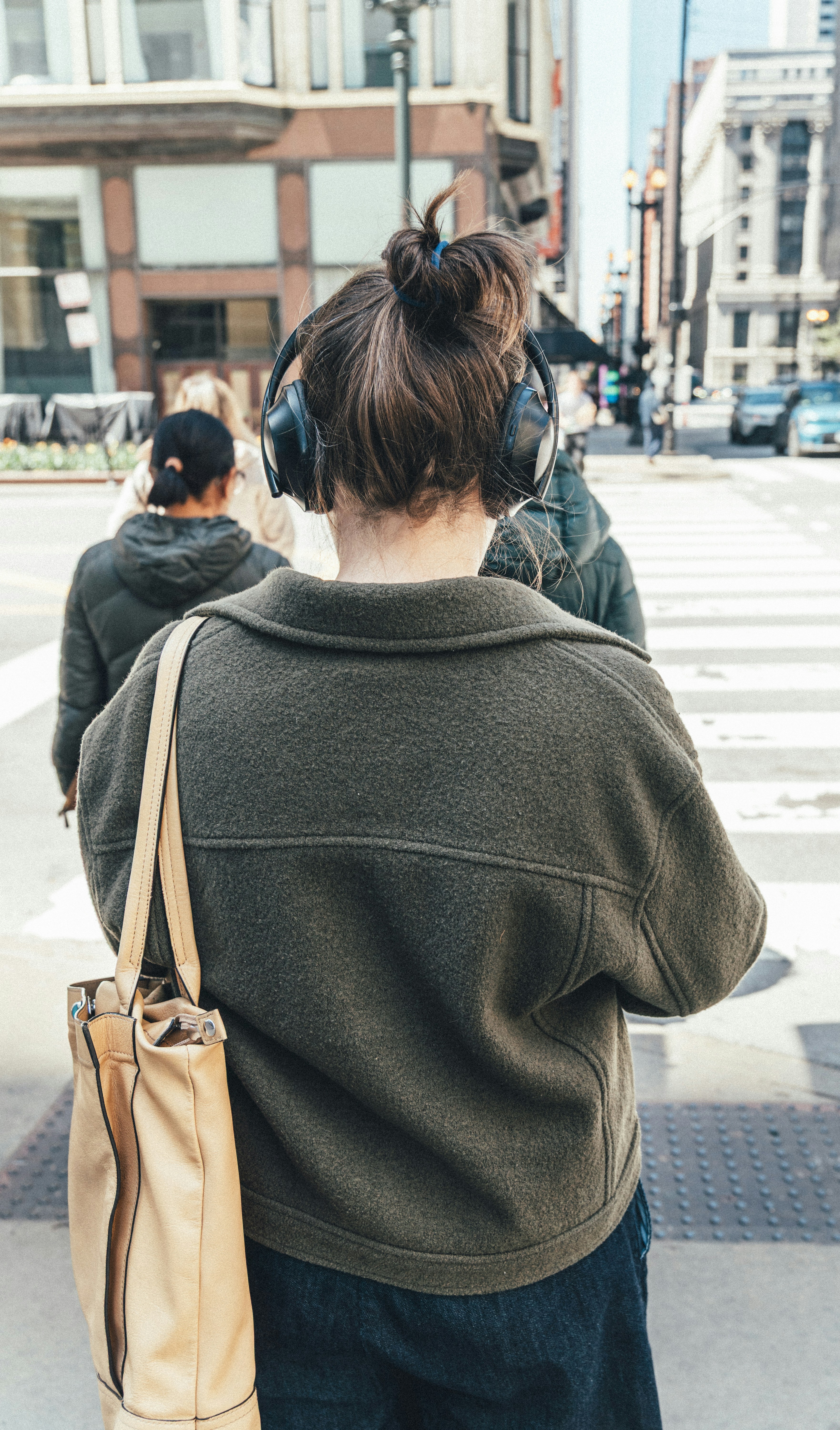 Urban Soundscape: A headphone-clad silhouette at a sunlit crosswalk