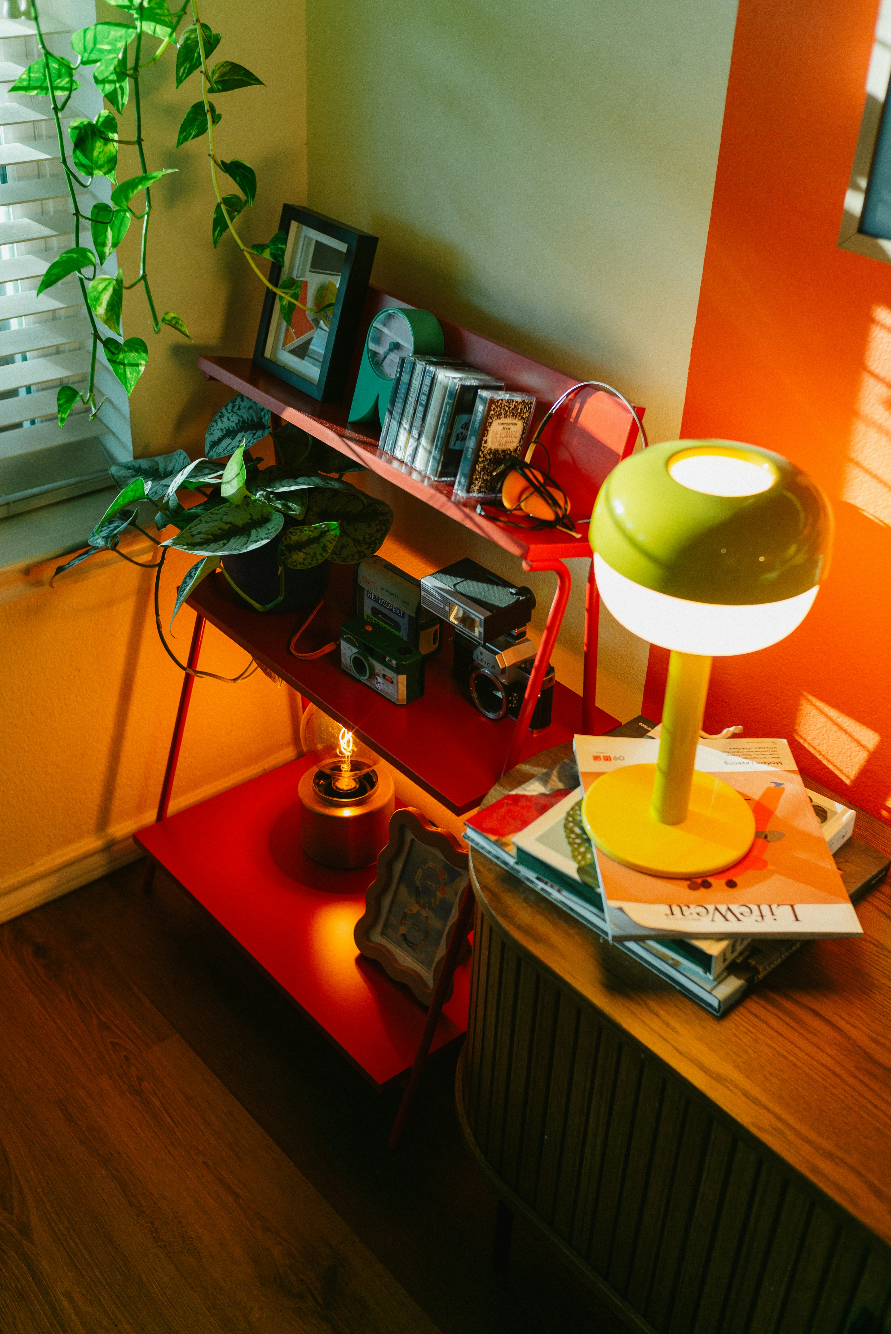 Cozy corner of color and light: a red shelf steadies a bright living vignette