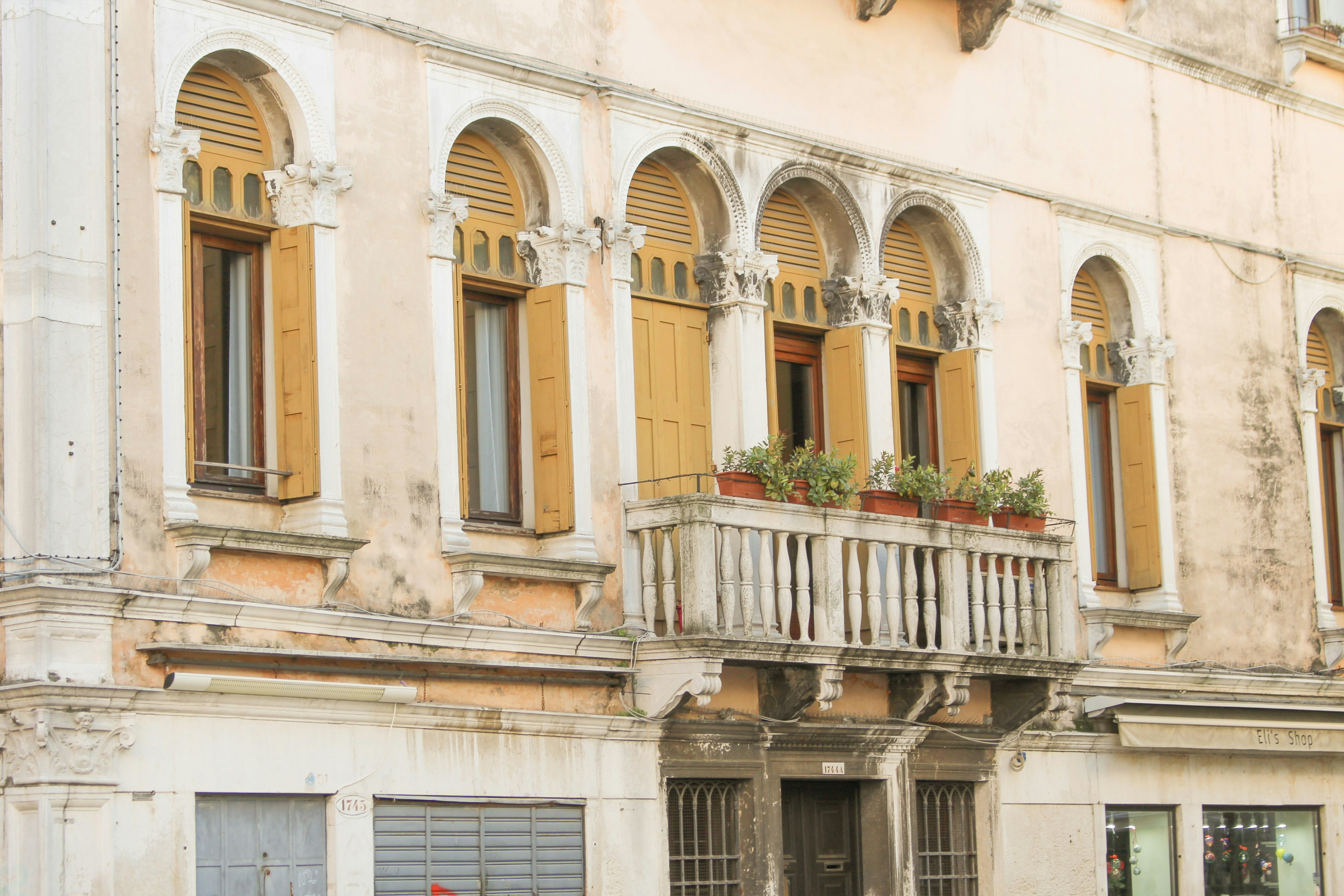 a postcard through time, the windows of italy look the same as they did years ago. the rich history of this country only bears a few scratches, weathered as a result of simply existing for so many years.