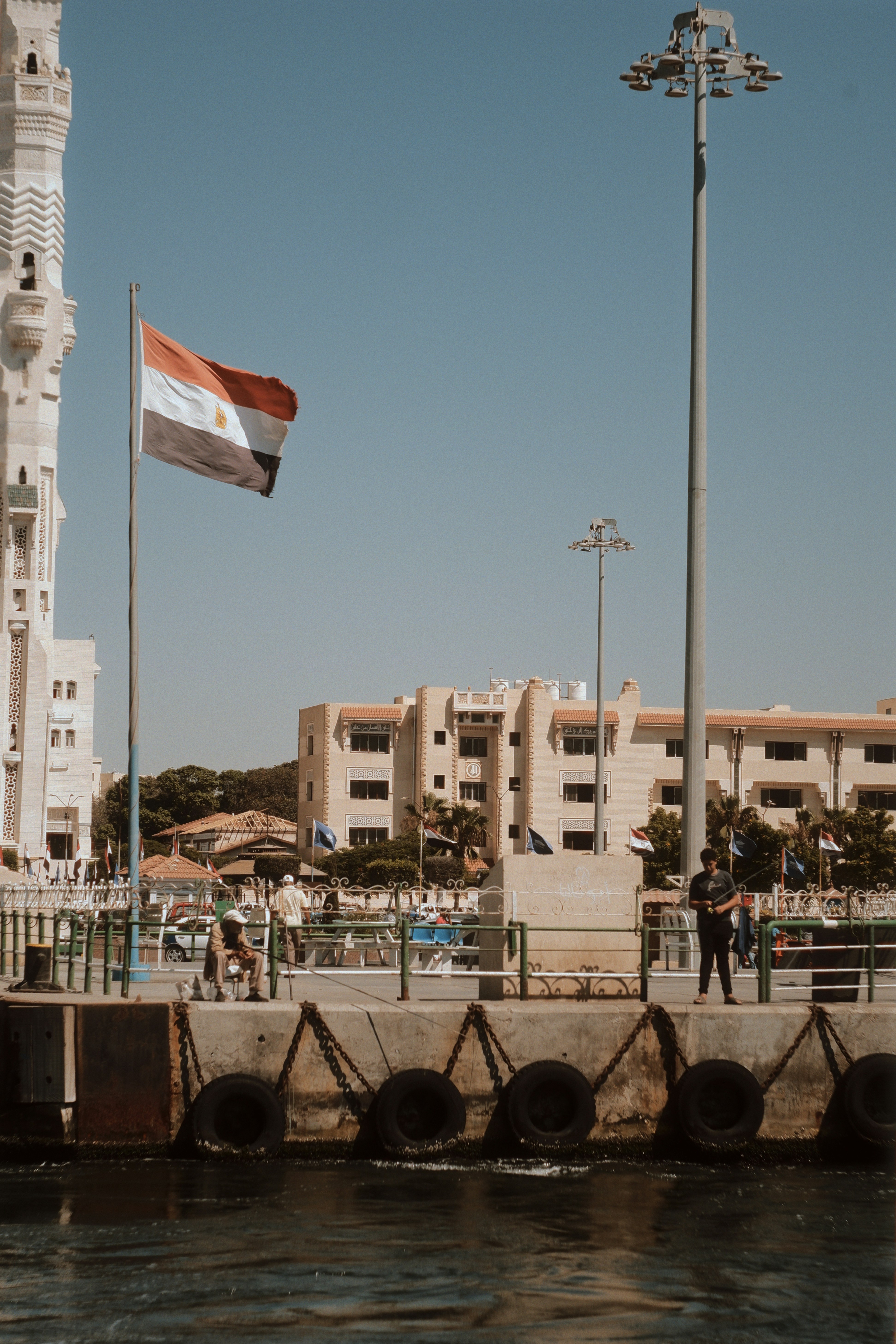 Flag over the harbor: cityscape and quay under a clear sky