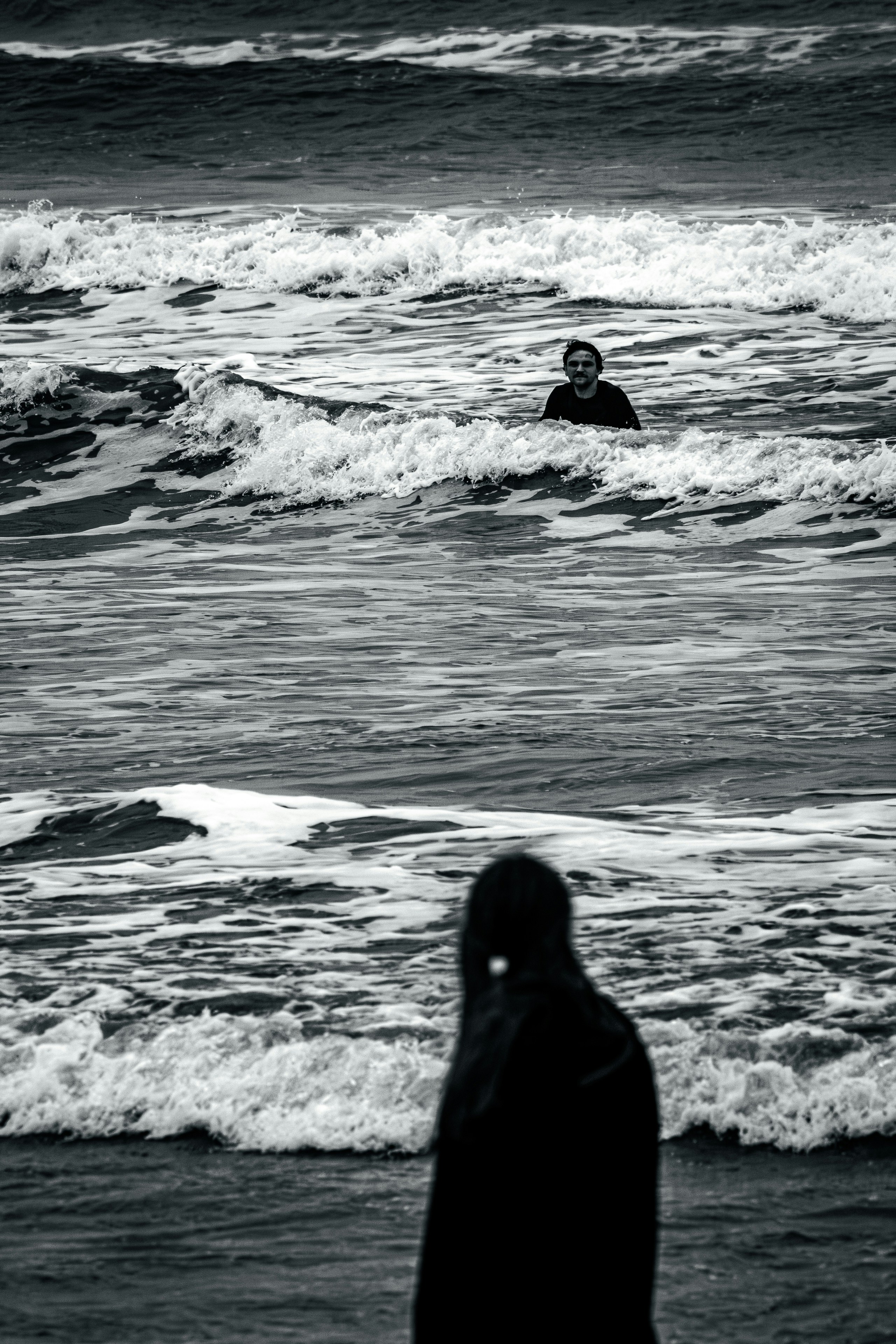 Surfer in Shadowed Crest: A Quiet Face in Rough Seas