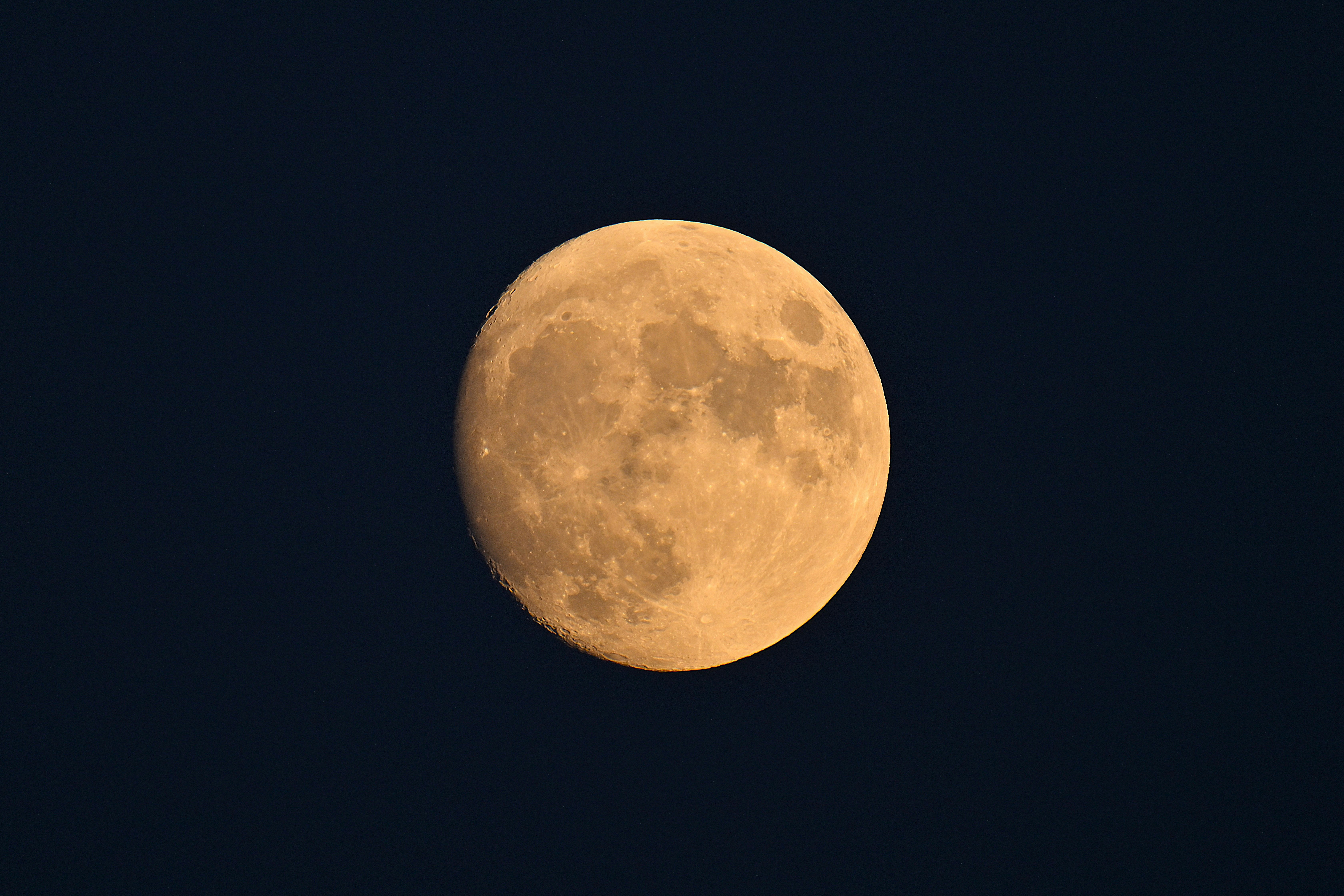 Lunar Ember: A Copper Moon Ascends from Night's Veil