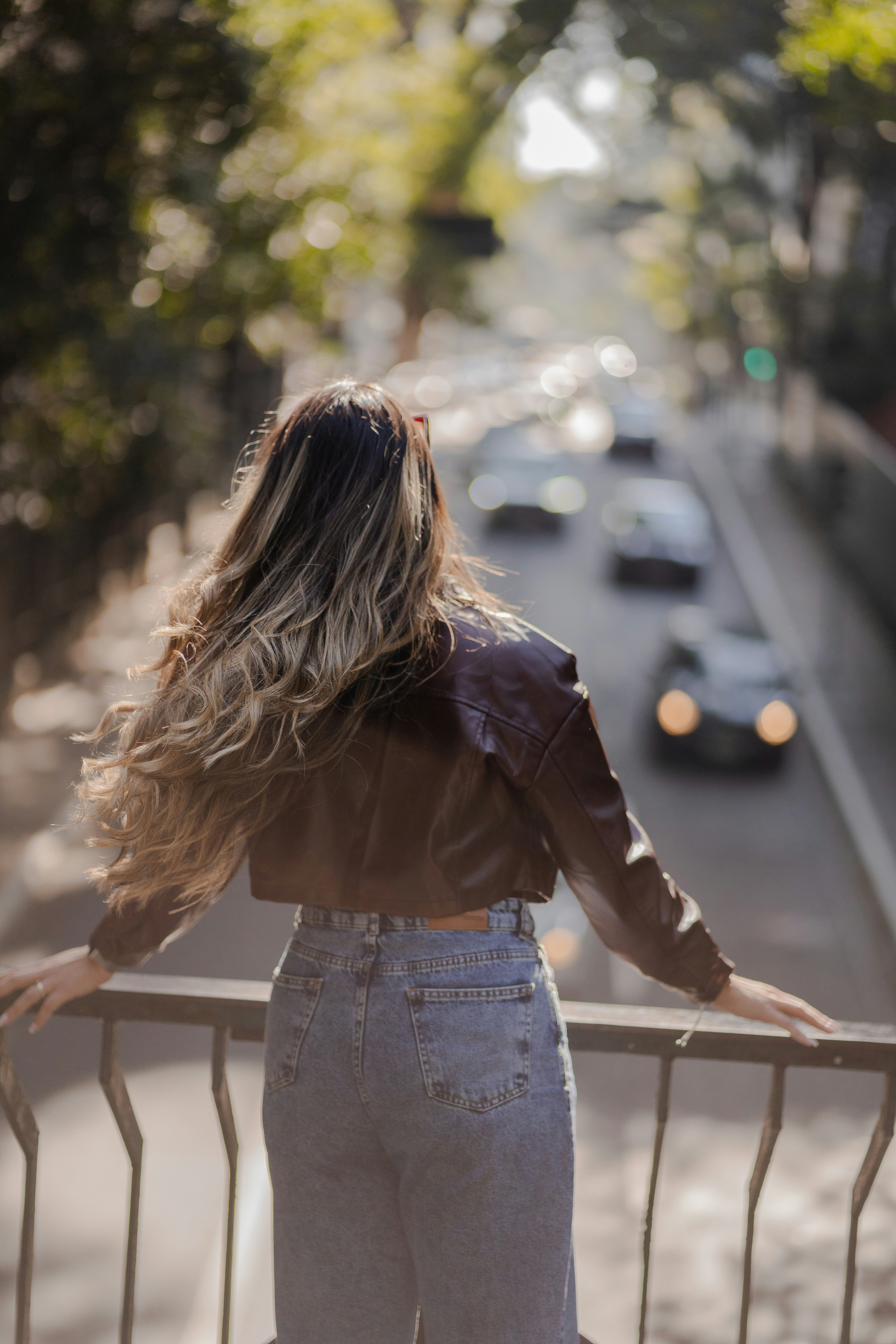 Over the Rail: A Citybound Moment with Windblown Hair