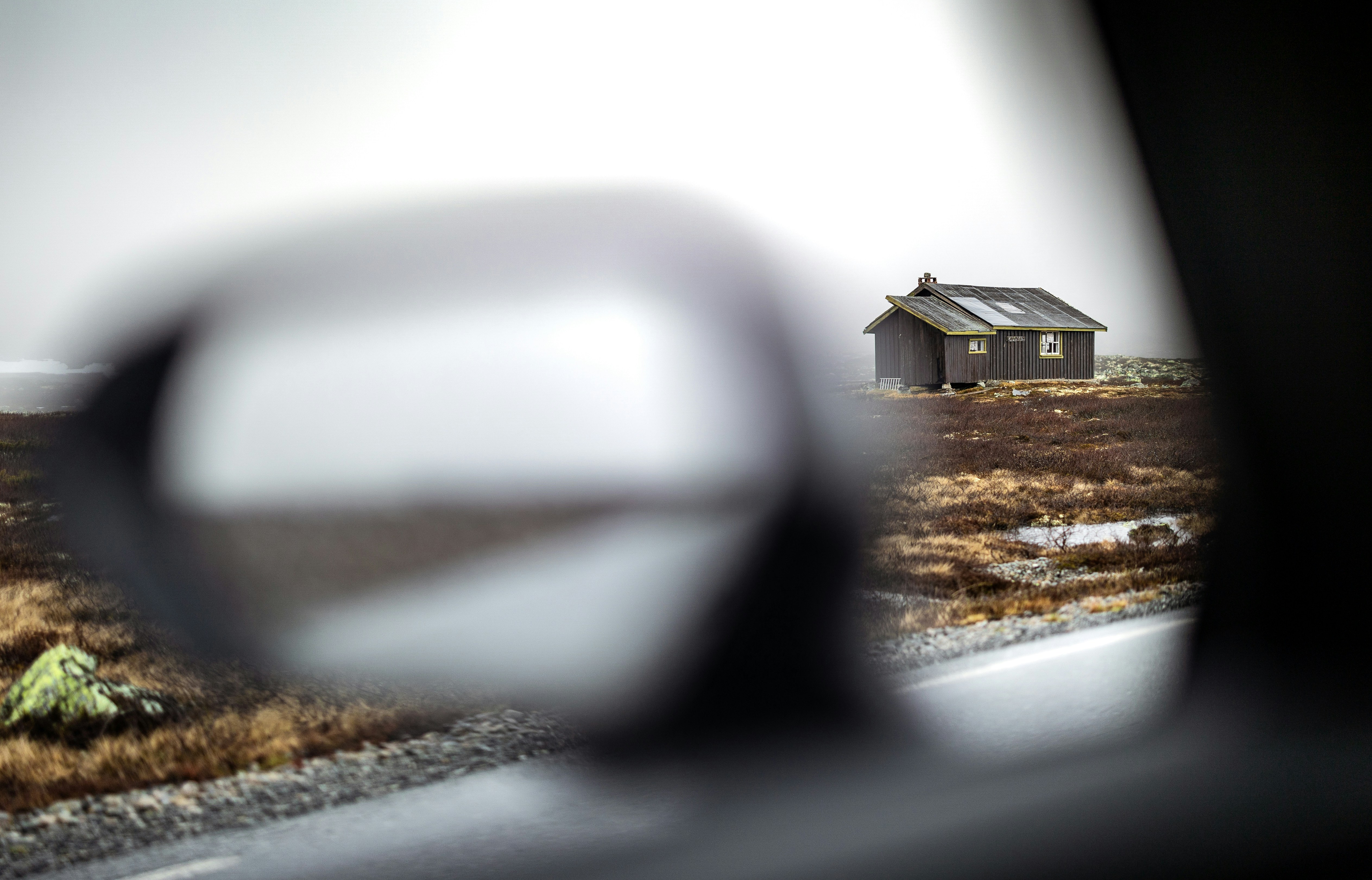 Rearview Mirror Moment: A Distant Shack Framed in a Car Window