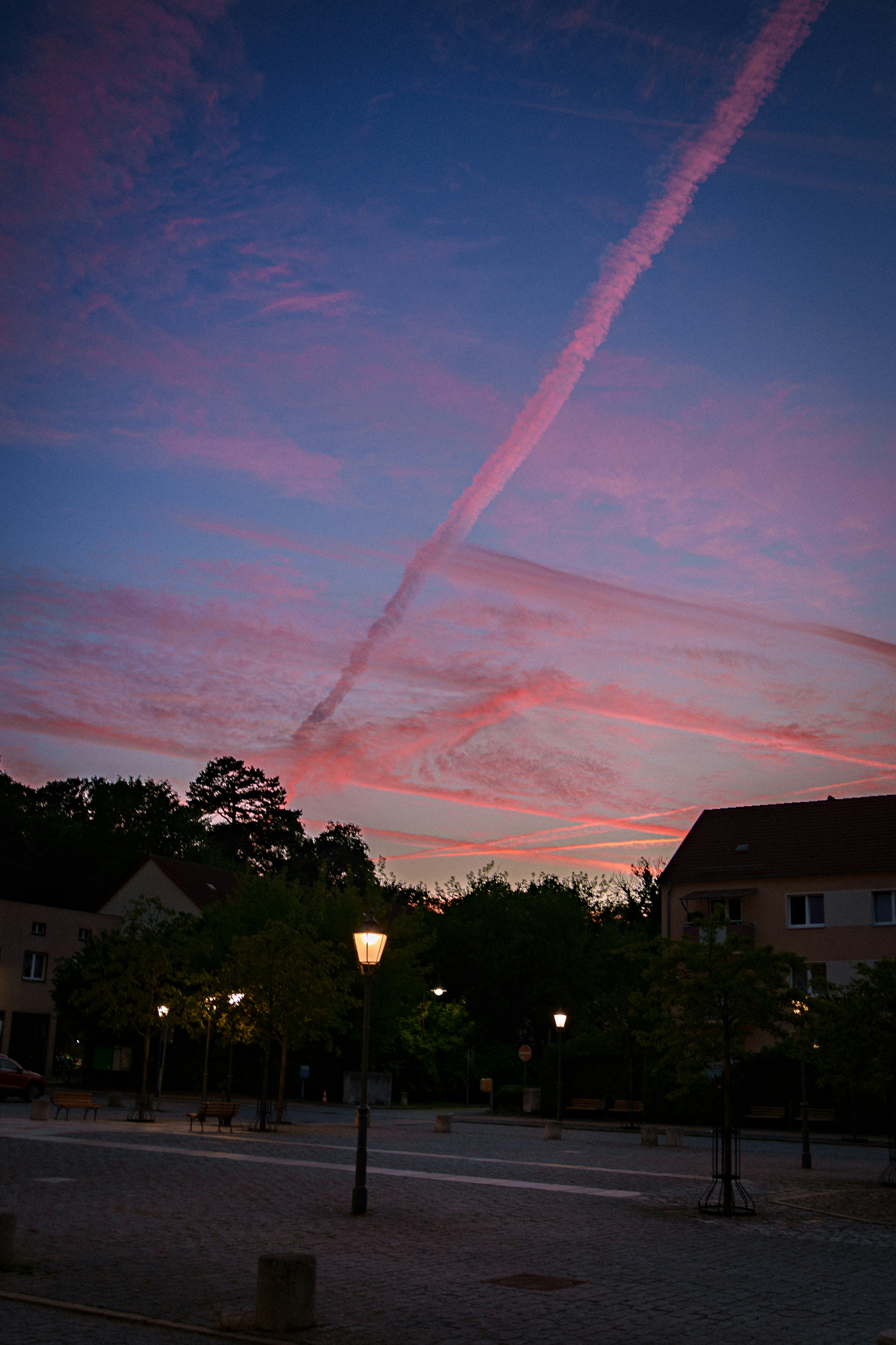 Dusk Crossing: Skylines and Contrails Over Quiet Squares