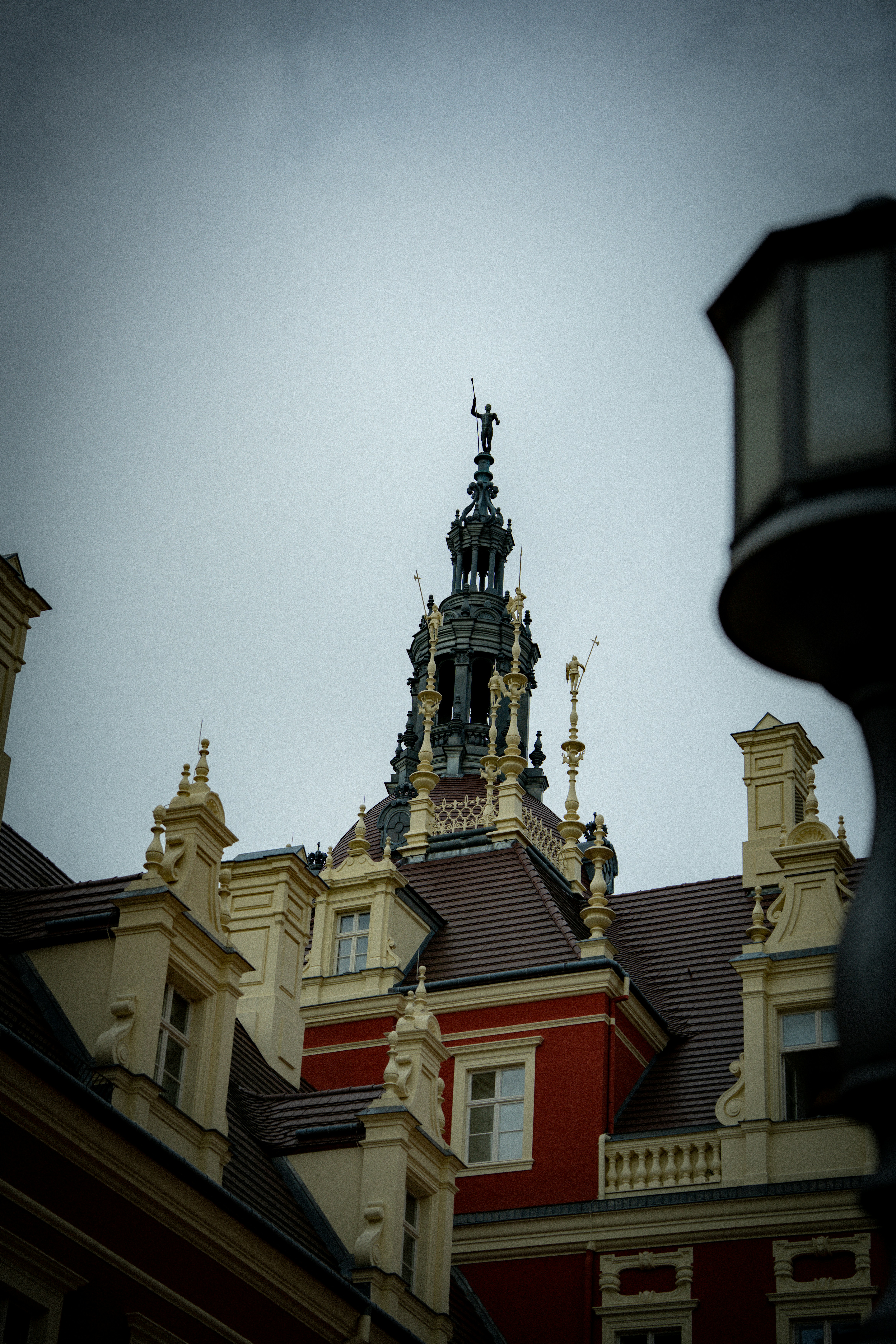 Tower Crowned by Sculpted Ornamentation Rises Above a Baroque Roofline