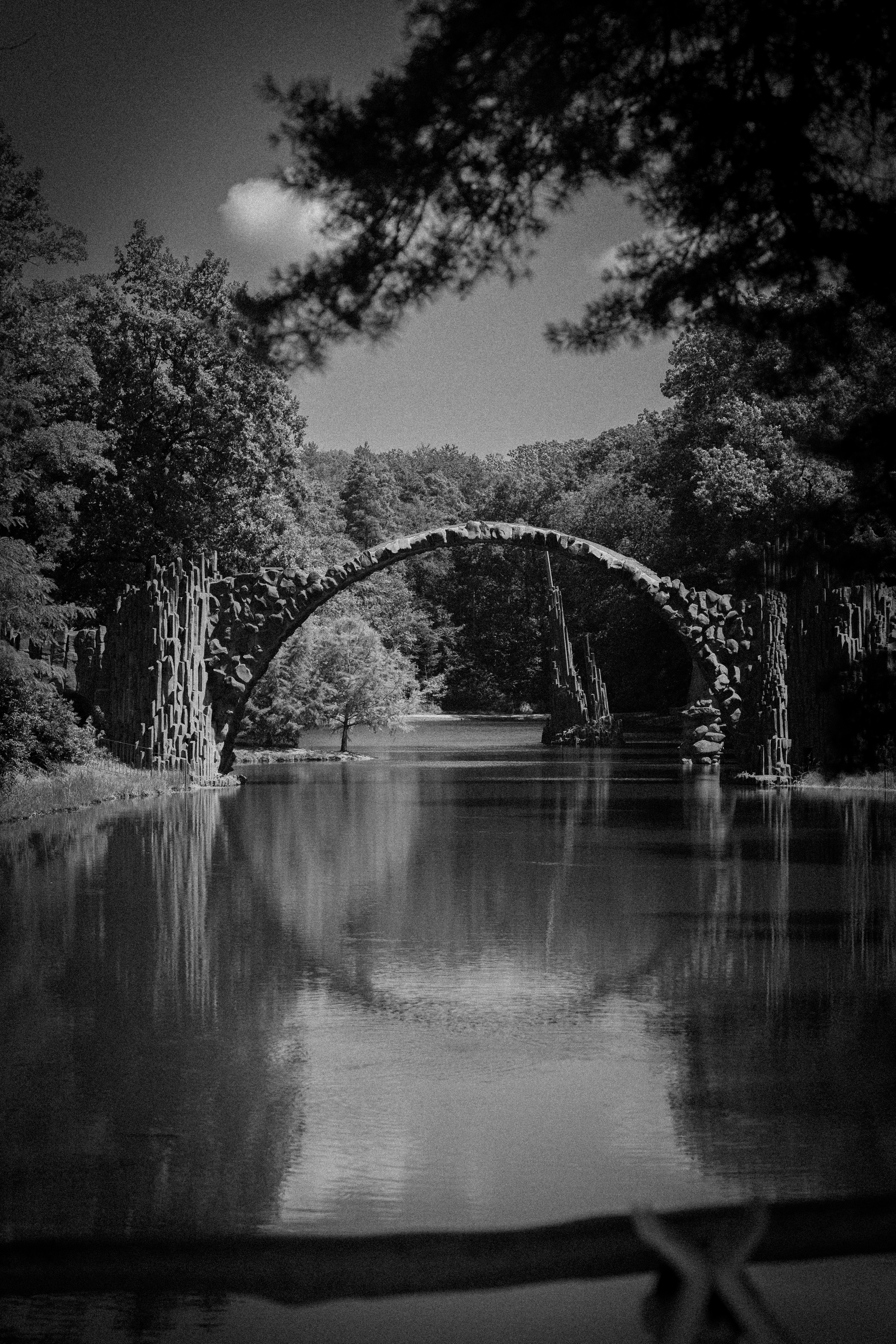Arching Bridge Over Tranquil Canal: A Monochrome Moment