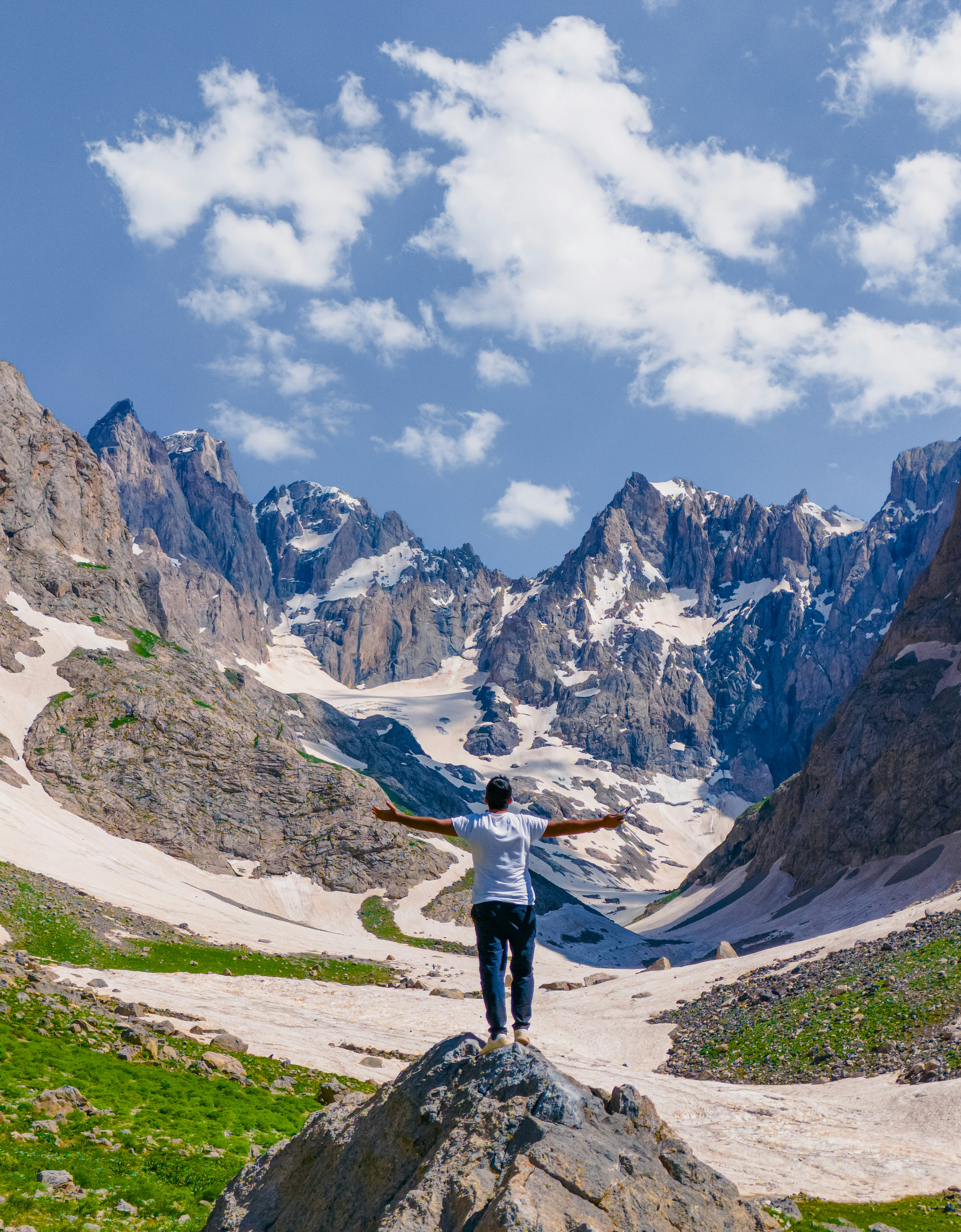 A solitary climber raises arms at alpine amphitheater