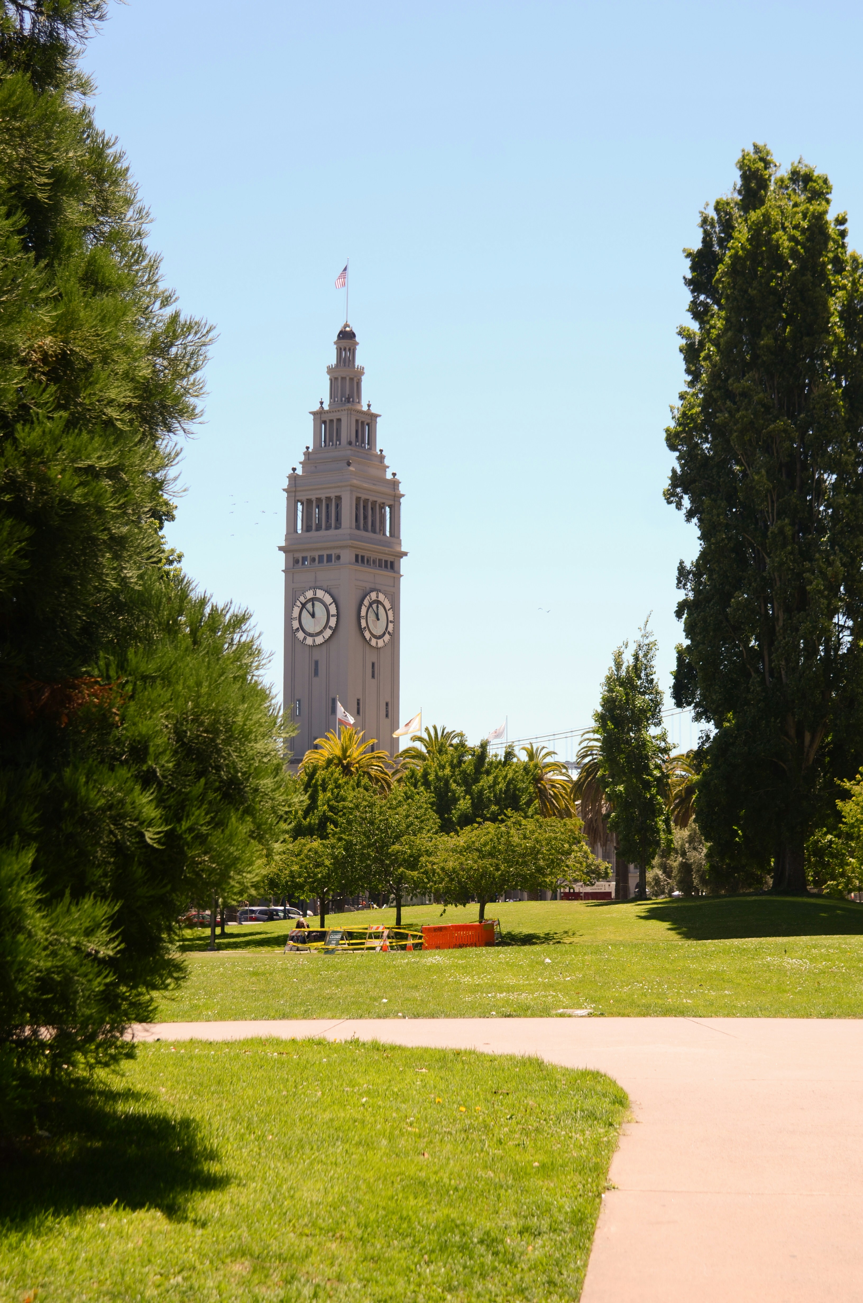 Clock Tower in a Sunlit Park Framed by Greenery