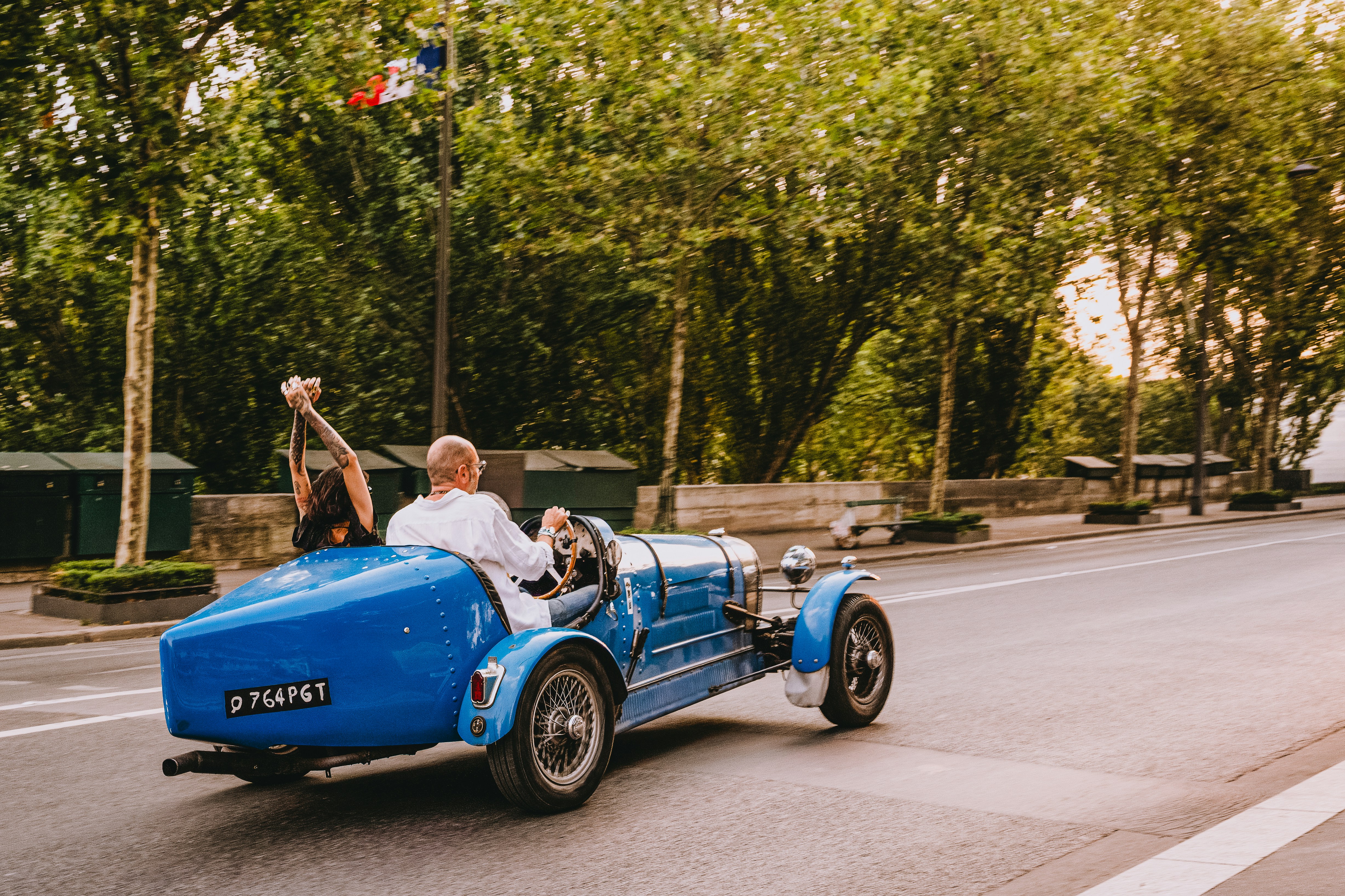 Vintage Blue Convertible Drift Down a Tree-Lined Street