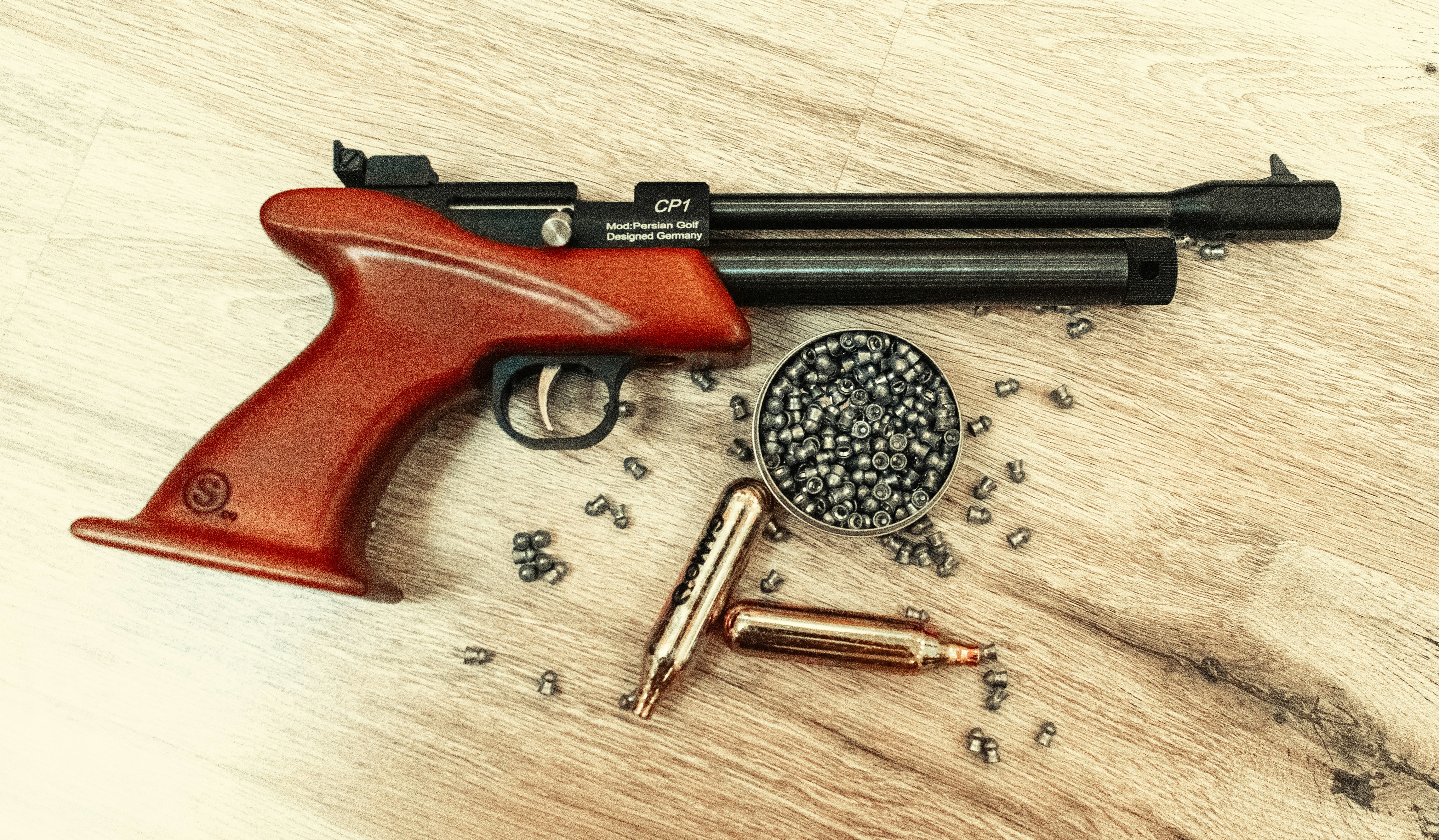 Precision and Silence: A Classic Pistol and Rounds on Weathered Wood