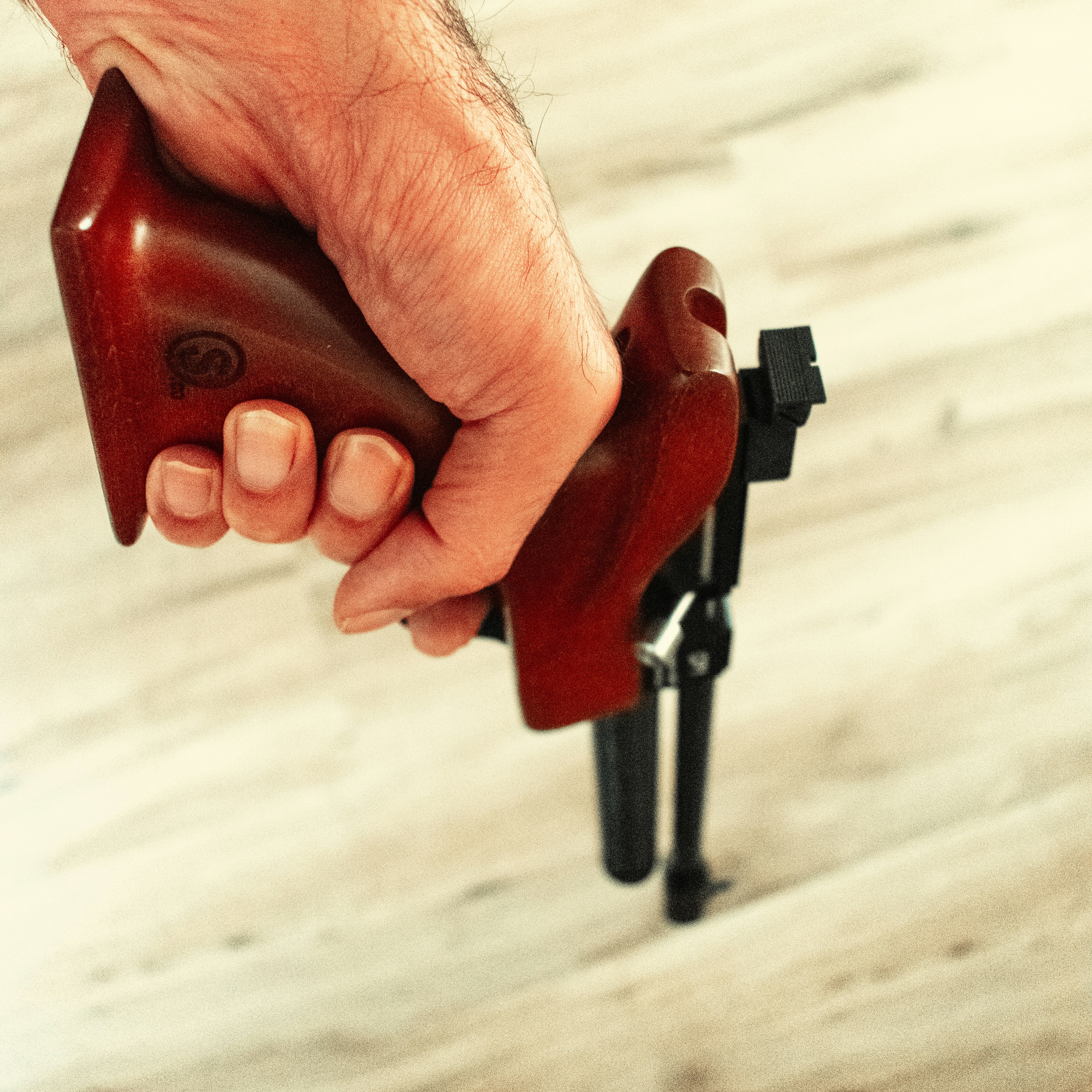 Grip and Glide: A Hand Clutching a Monitor Handle Against a Wooden Floor