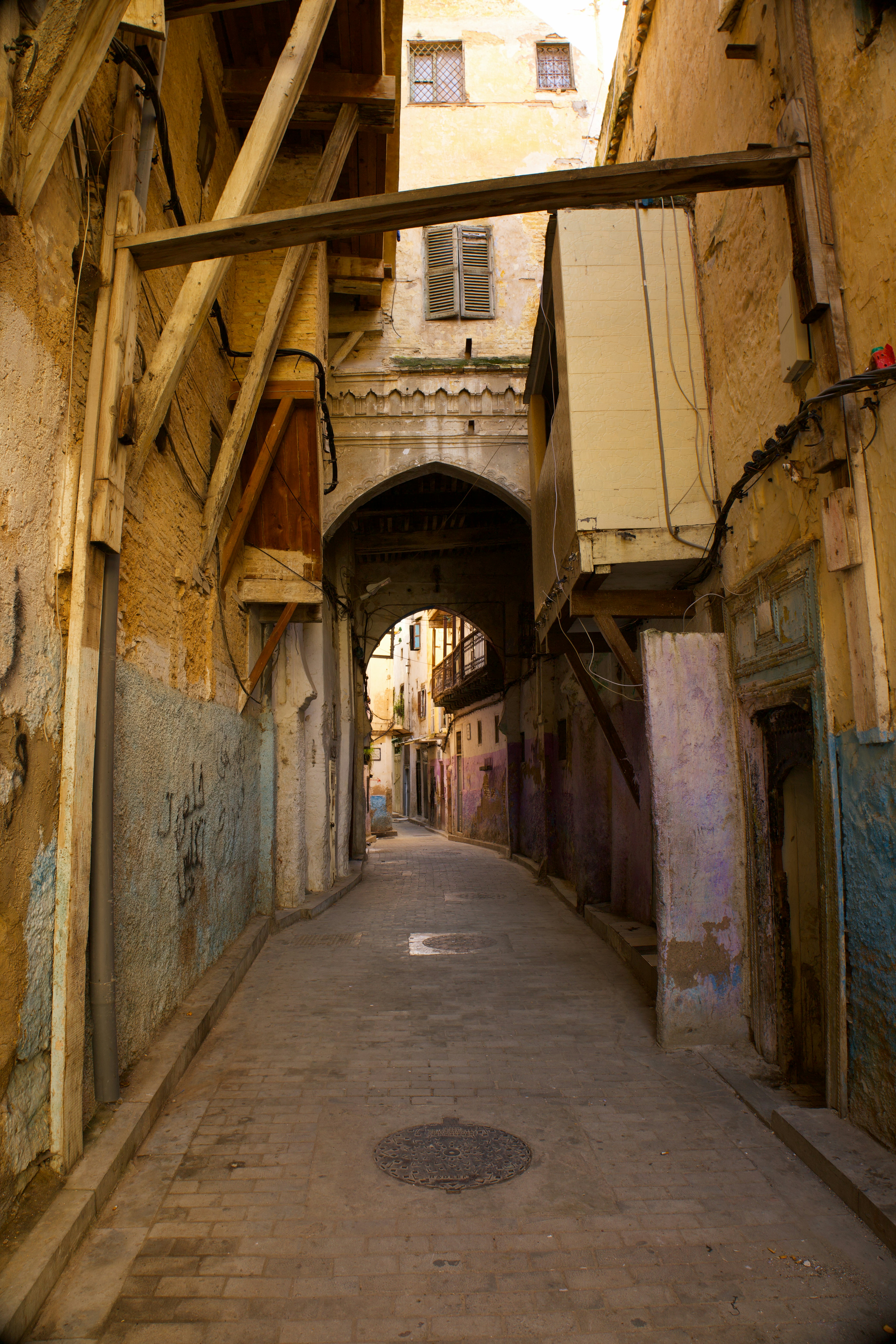 Archway Dawn: A Narrow Moroccan Alley Framed by Weathered Facades