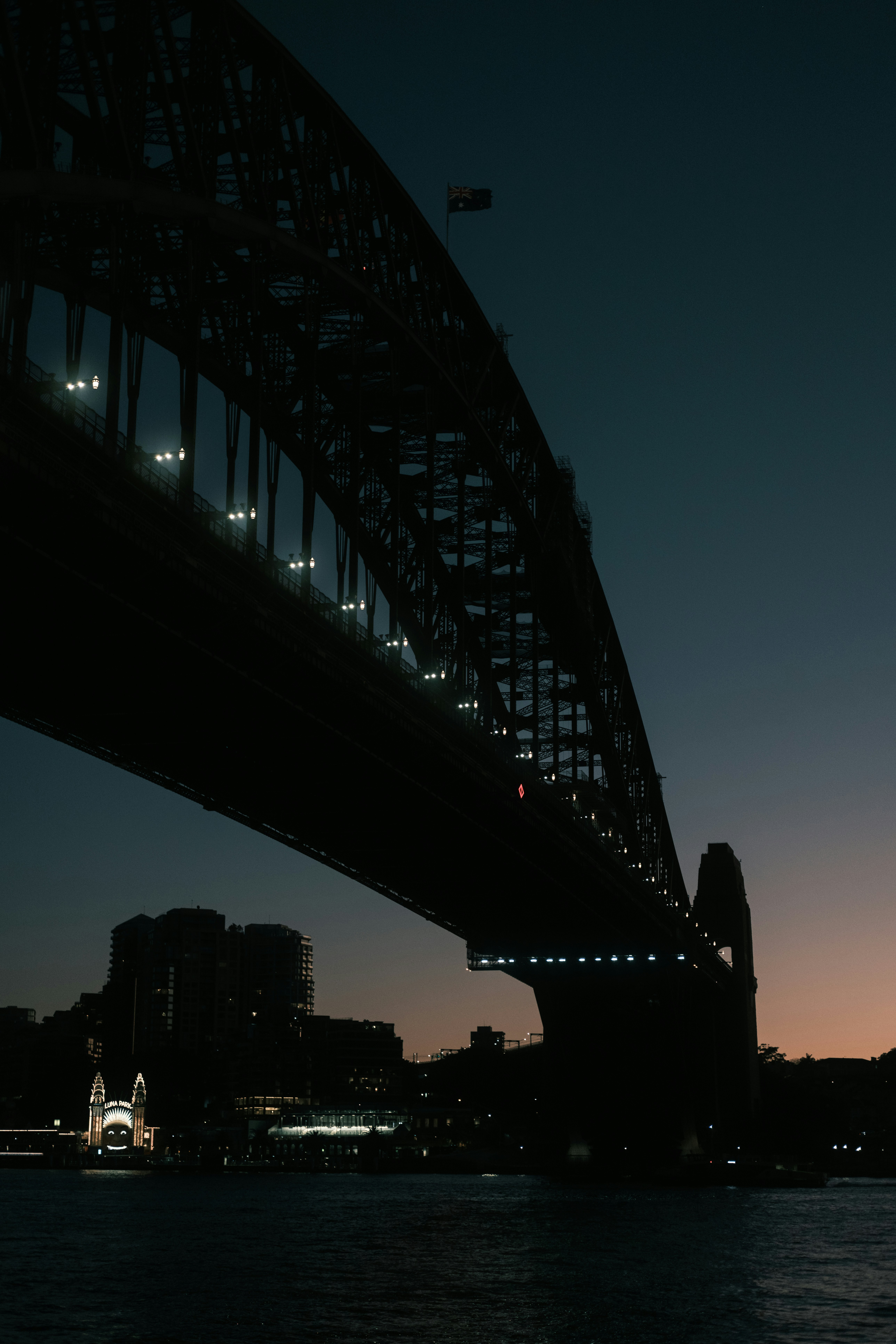 Dusk Over the Arched Horizon: Sydney-Style Bridge Piercing the Smoke