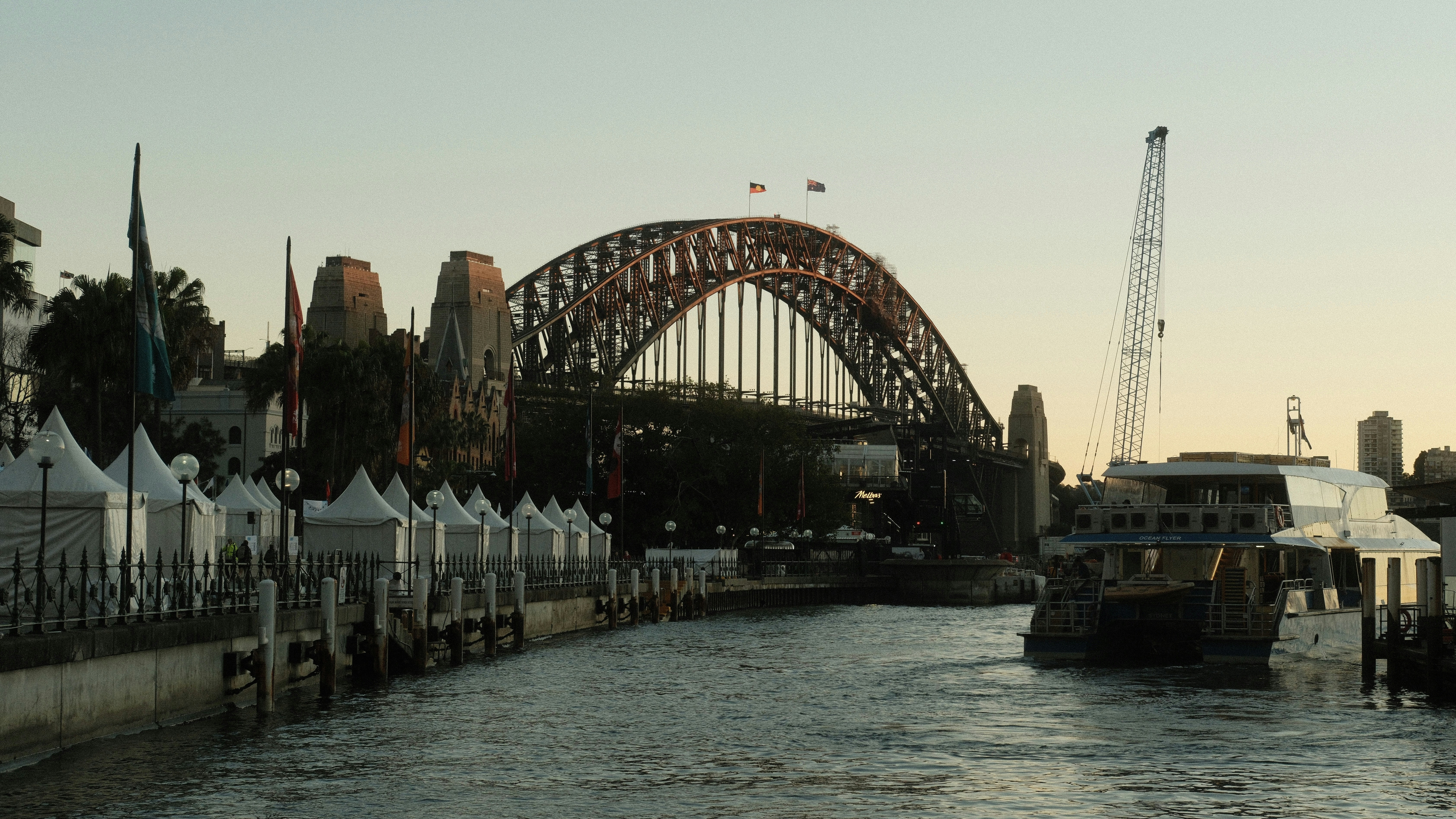 Harbor Confluence: The Bridge, Boats, and Tents at Dusk
