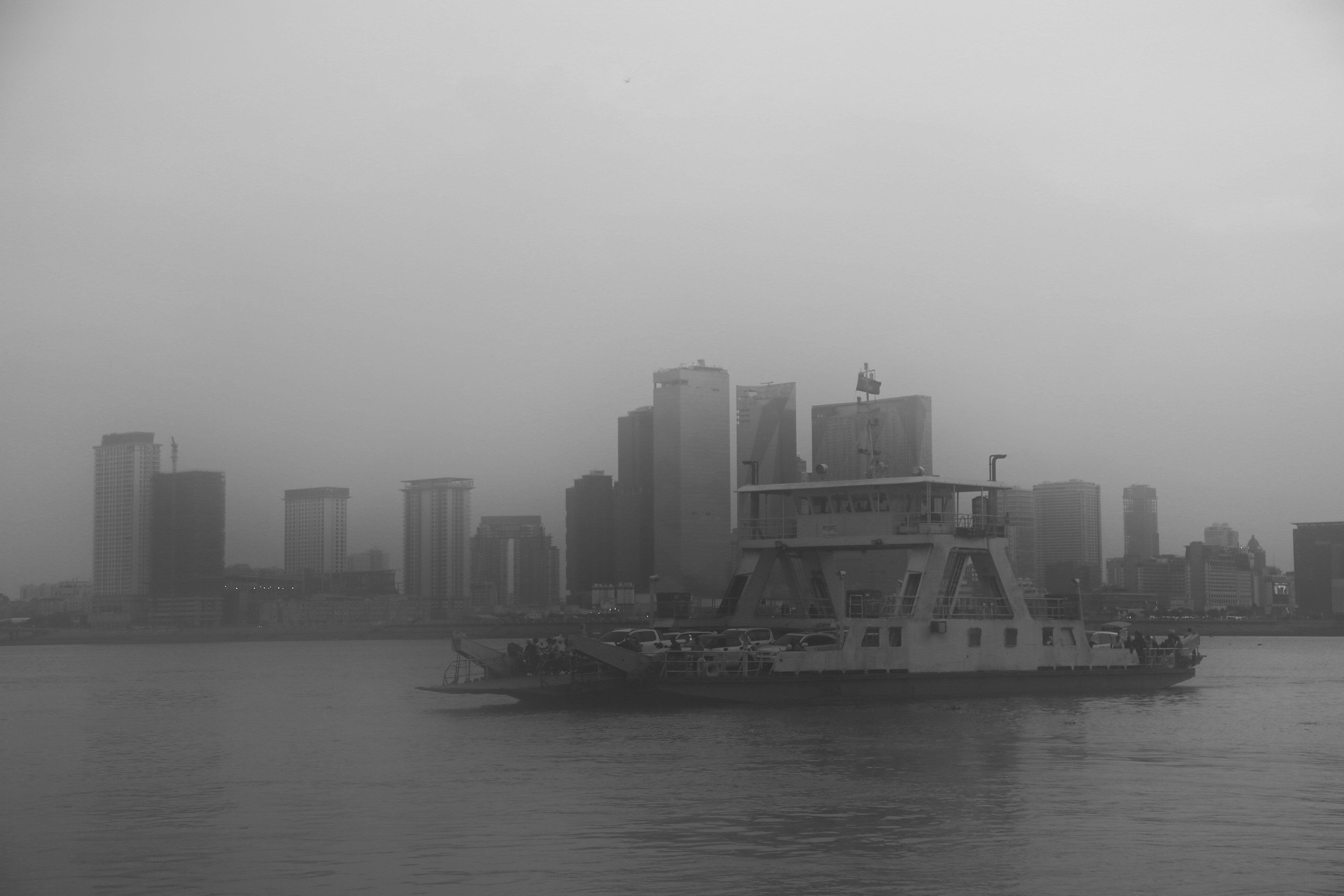 Harbor Vessel at Dusk: Concrete Skyline in Fog