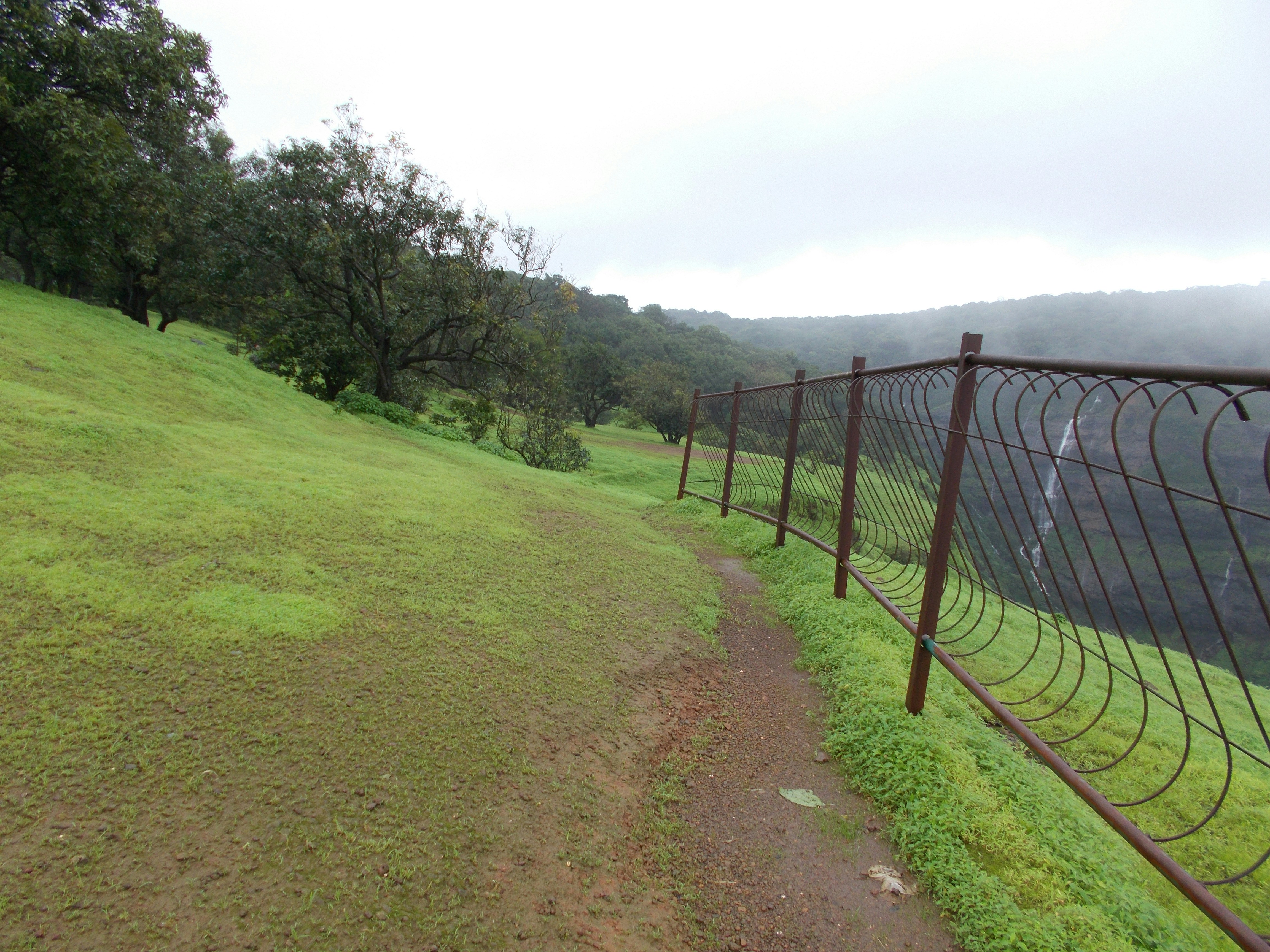 Fence Footpath Along a Misty Hillside